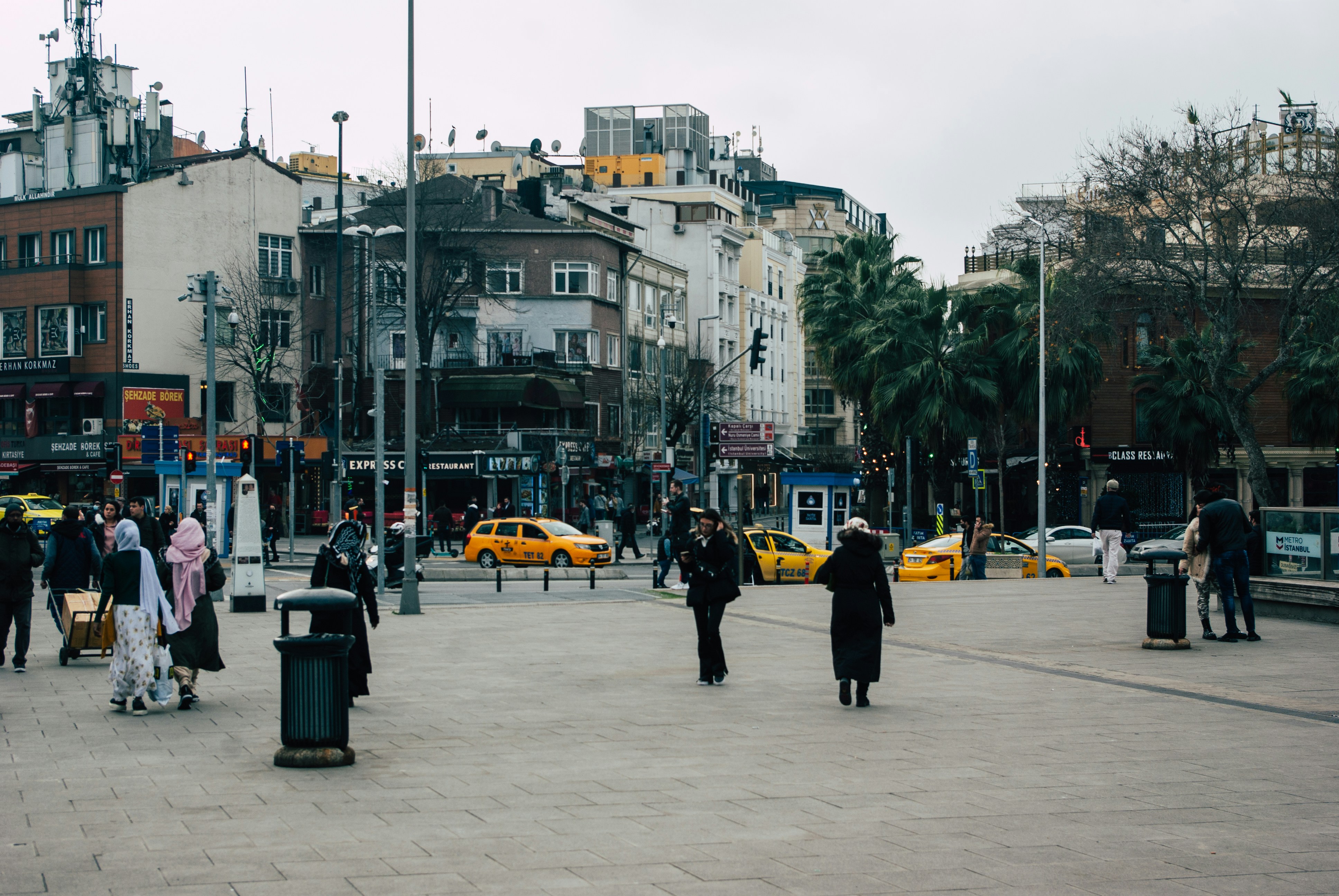 A group of people walking around a city square photo – Free Downtown ...