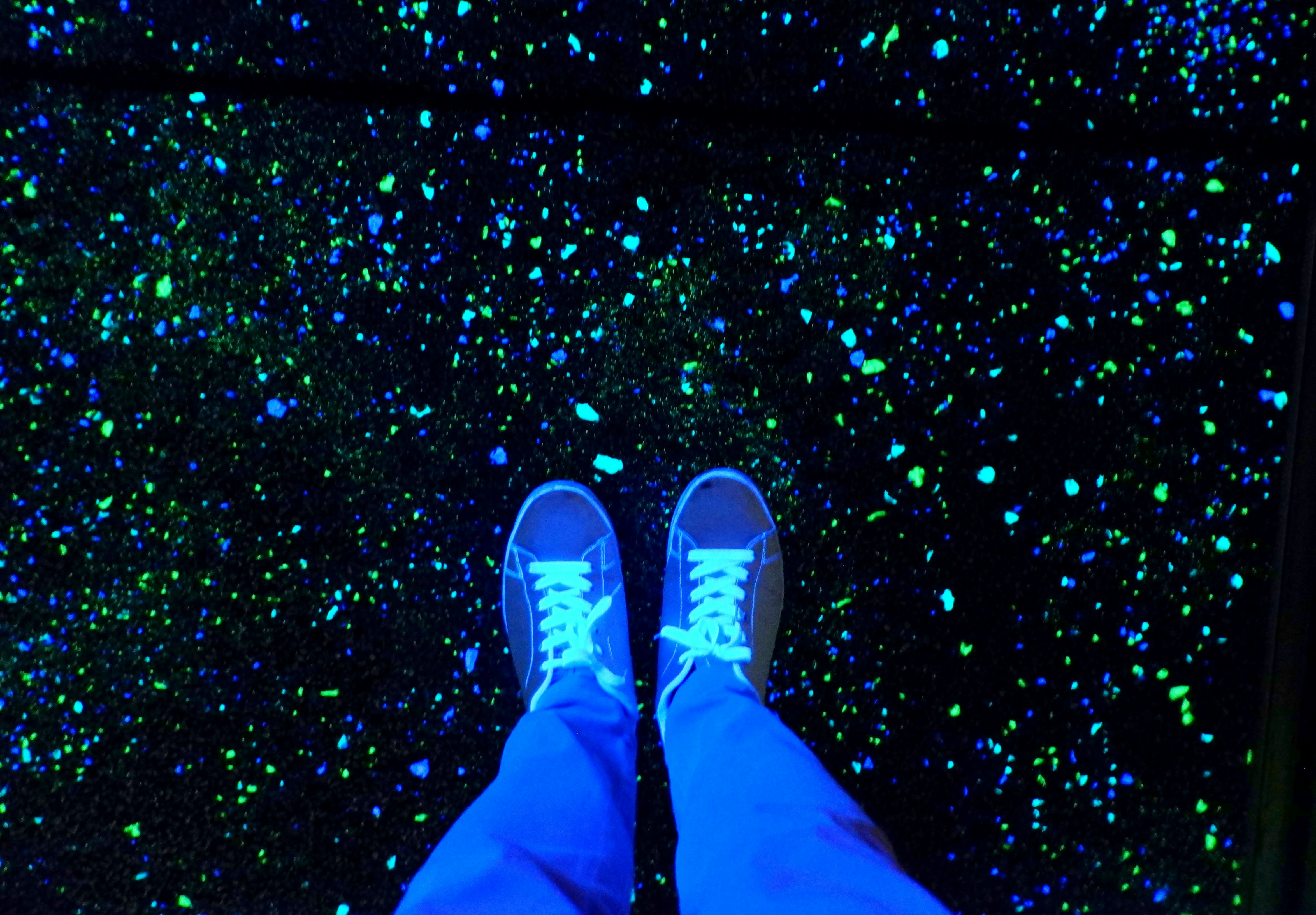 Top-Down Glow: Neon Specks Beneath Blue Sneakers