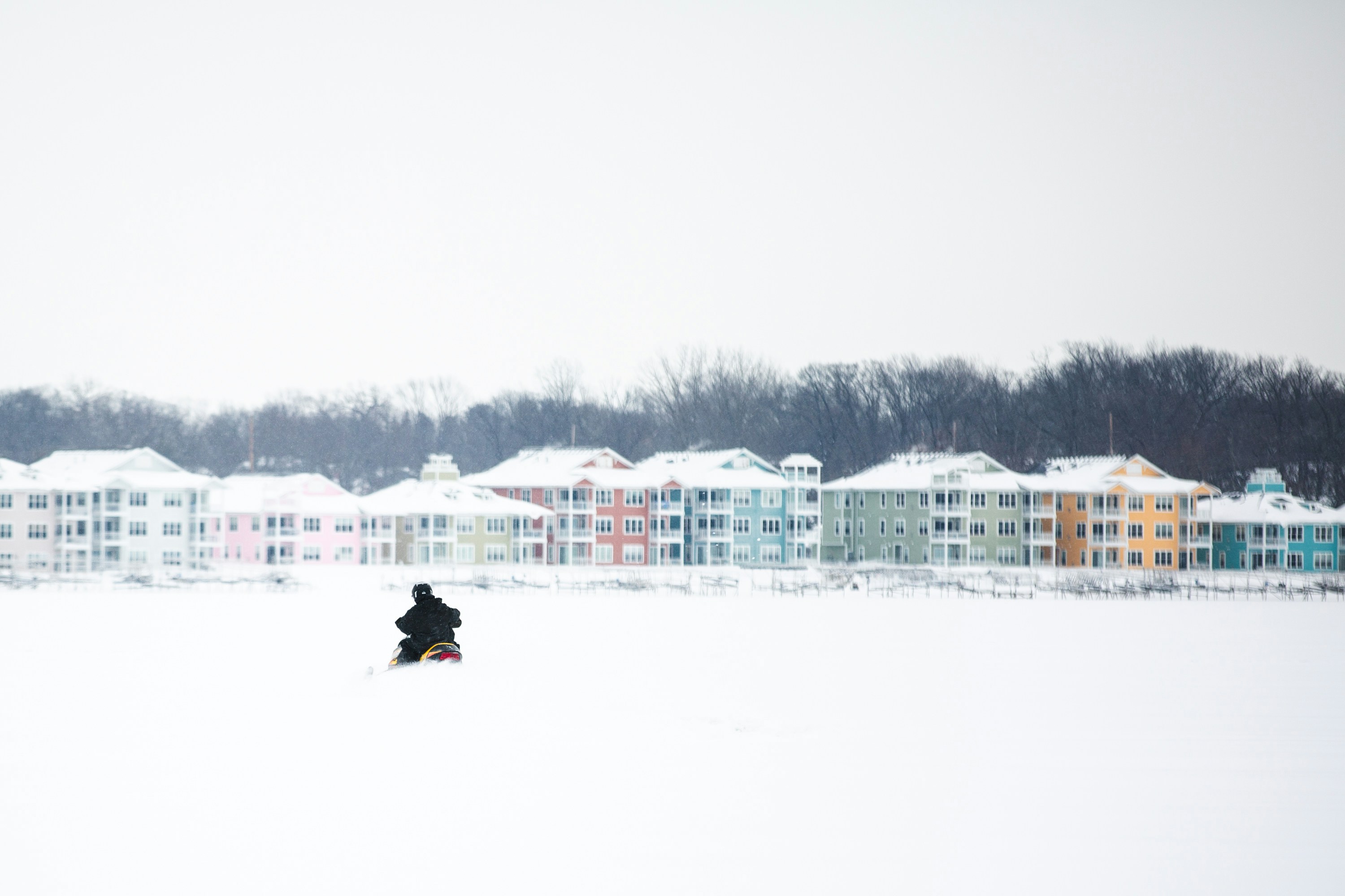 Snowbound Rider Near a Row of Pastel Houses