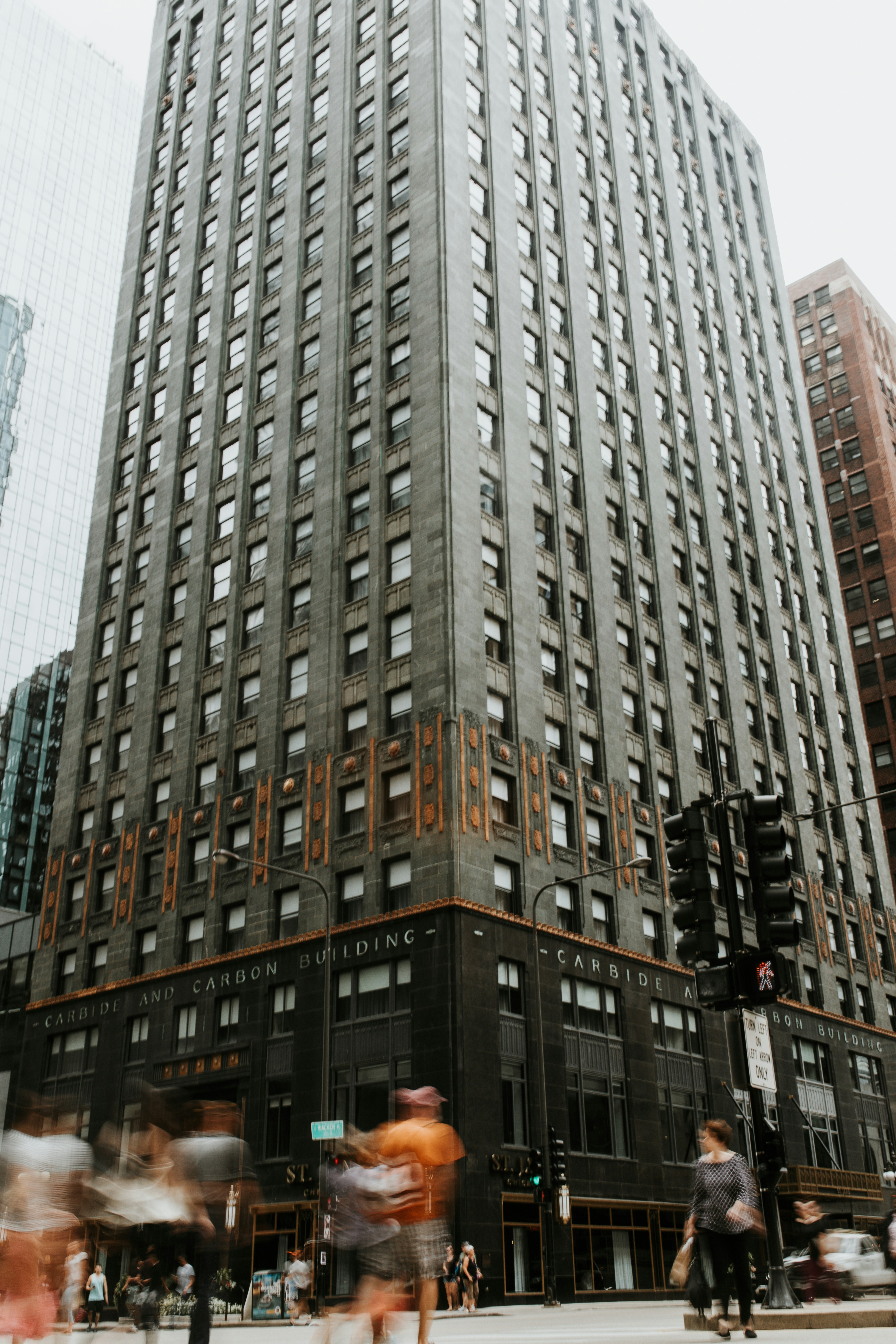 A group of people crossing a street in front of a tall building photo ...