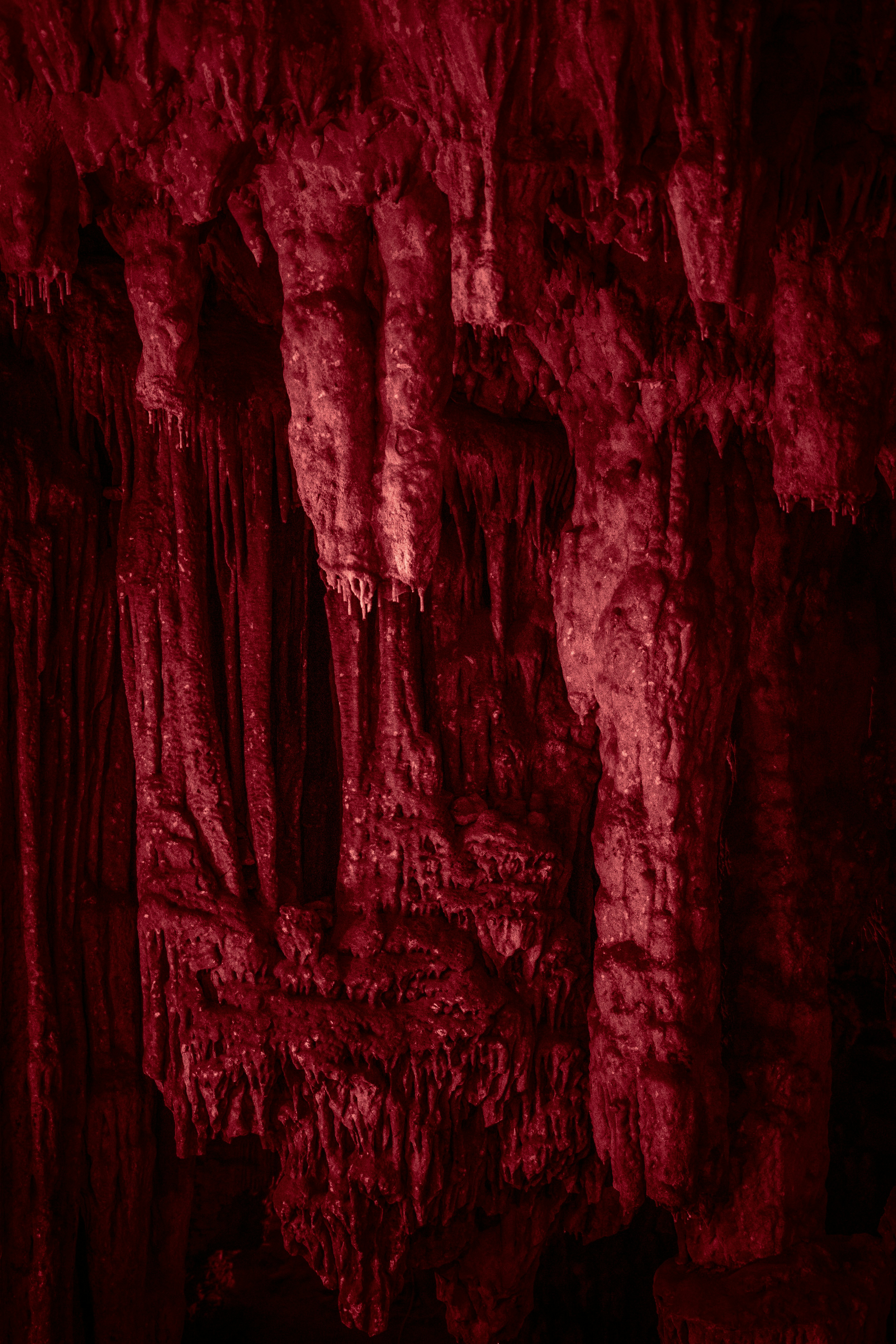 A large cave with red light coming from the ceiling photo – Free Cave ...