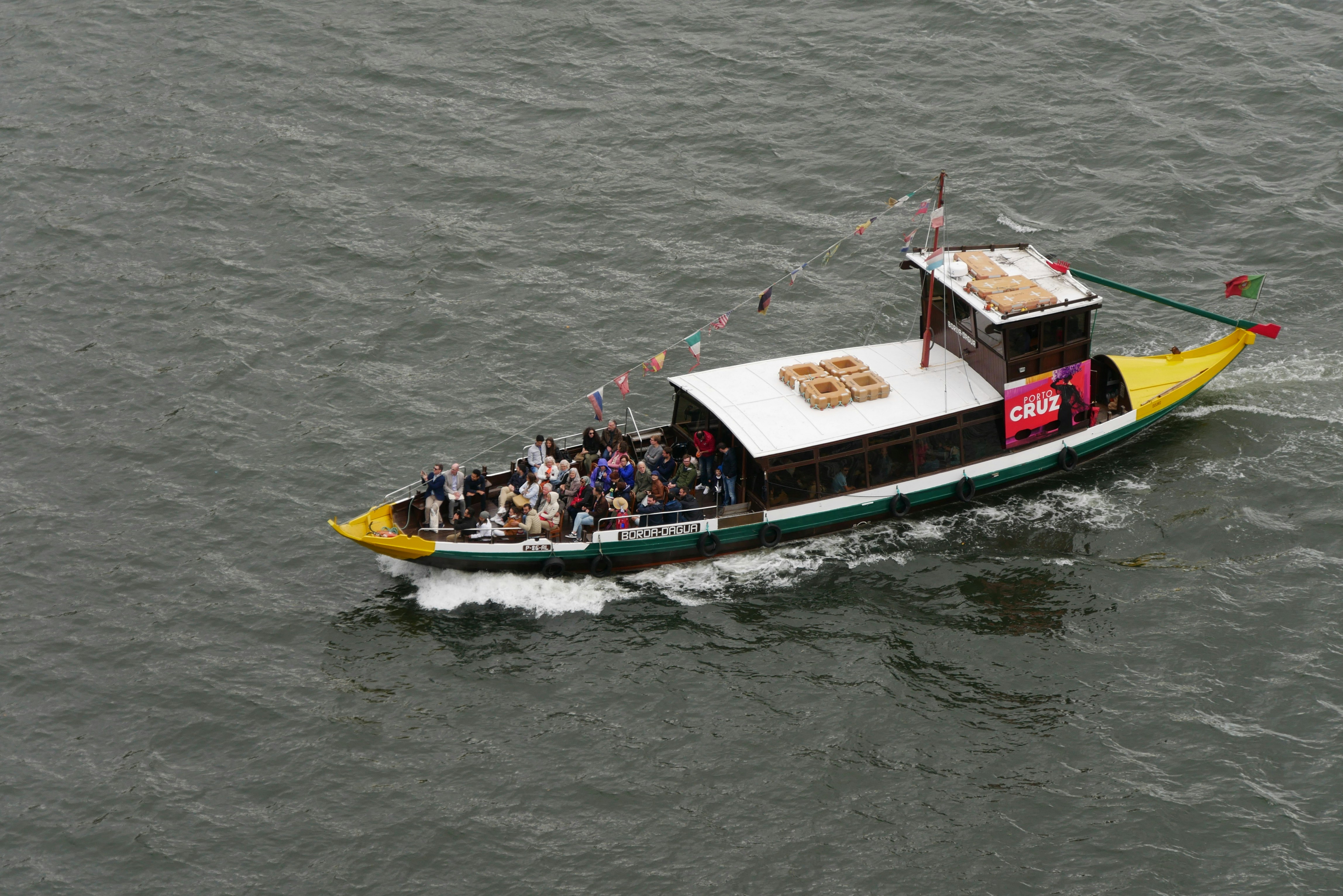 a boat filled with people riding on top of a body of water