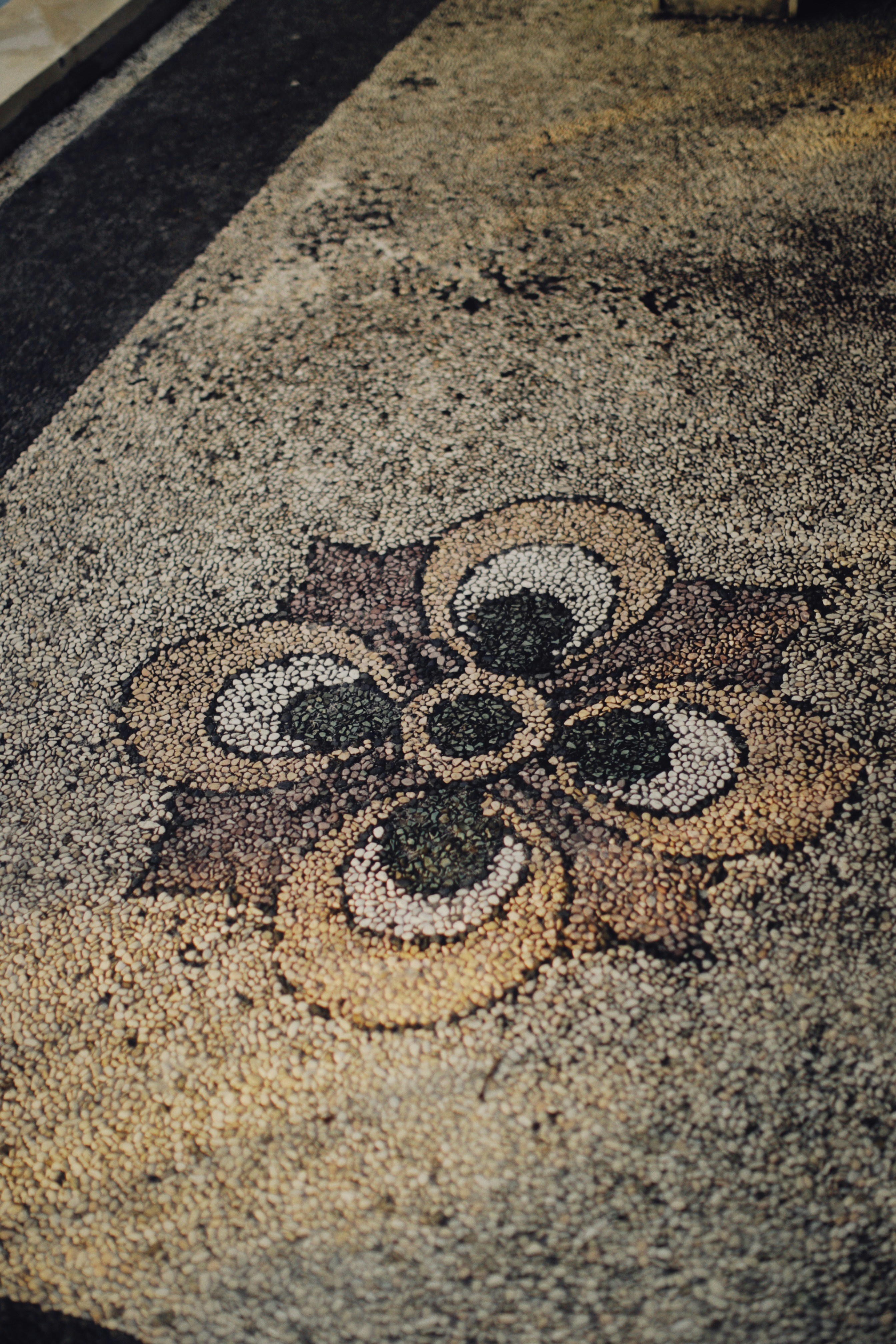 Pebble Flower Mosaic: A Quiet Bloom on Weathered Pavement
