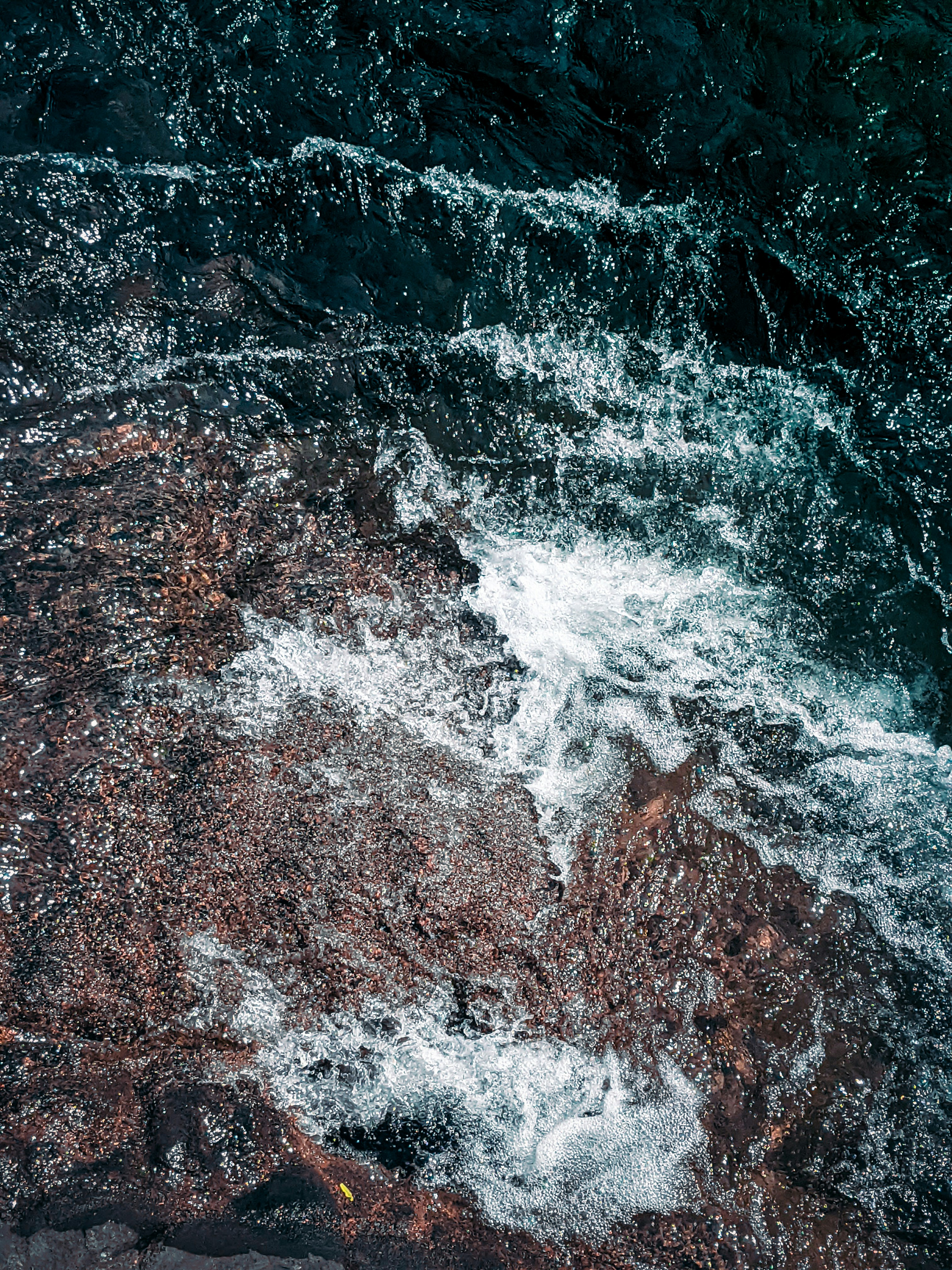 A large body of water surrounded by rocks photo – Free Tide Image on ...