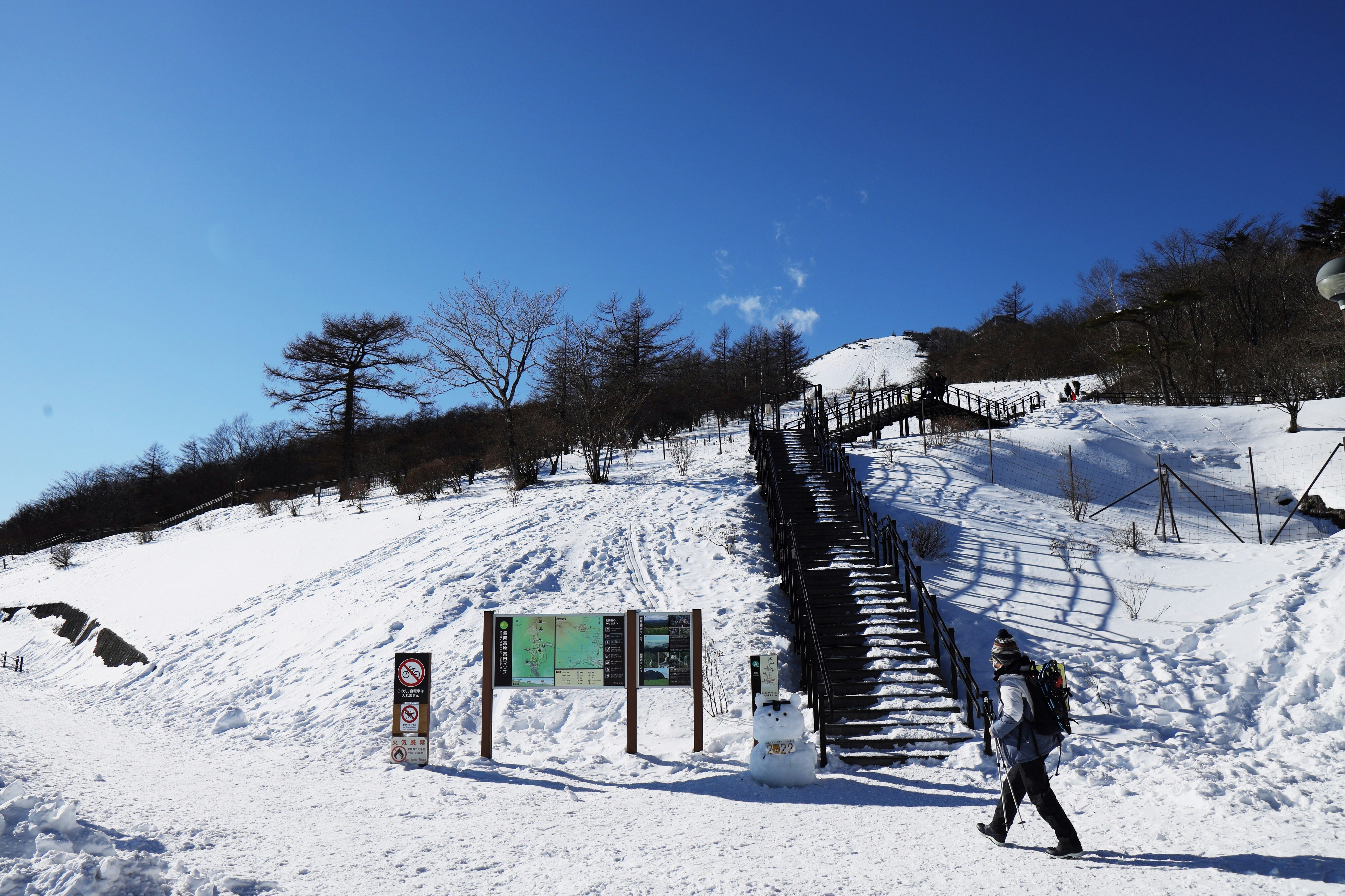 A man walking up a snow covered slope photo – Free Human Image on Unsplash