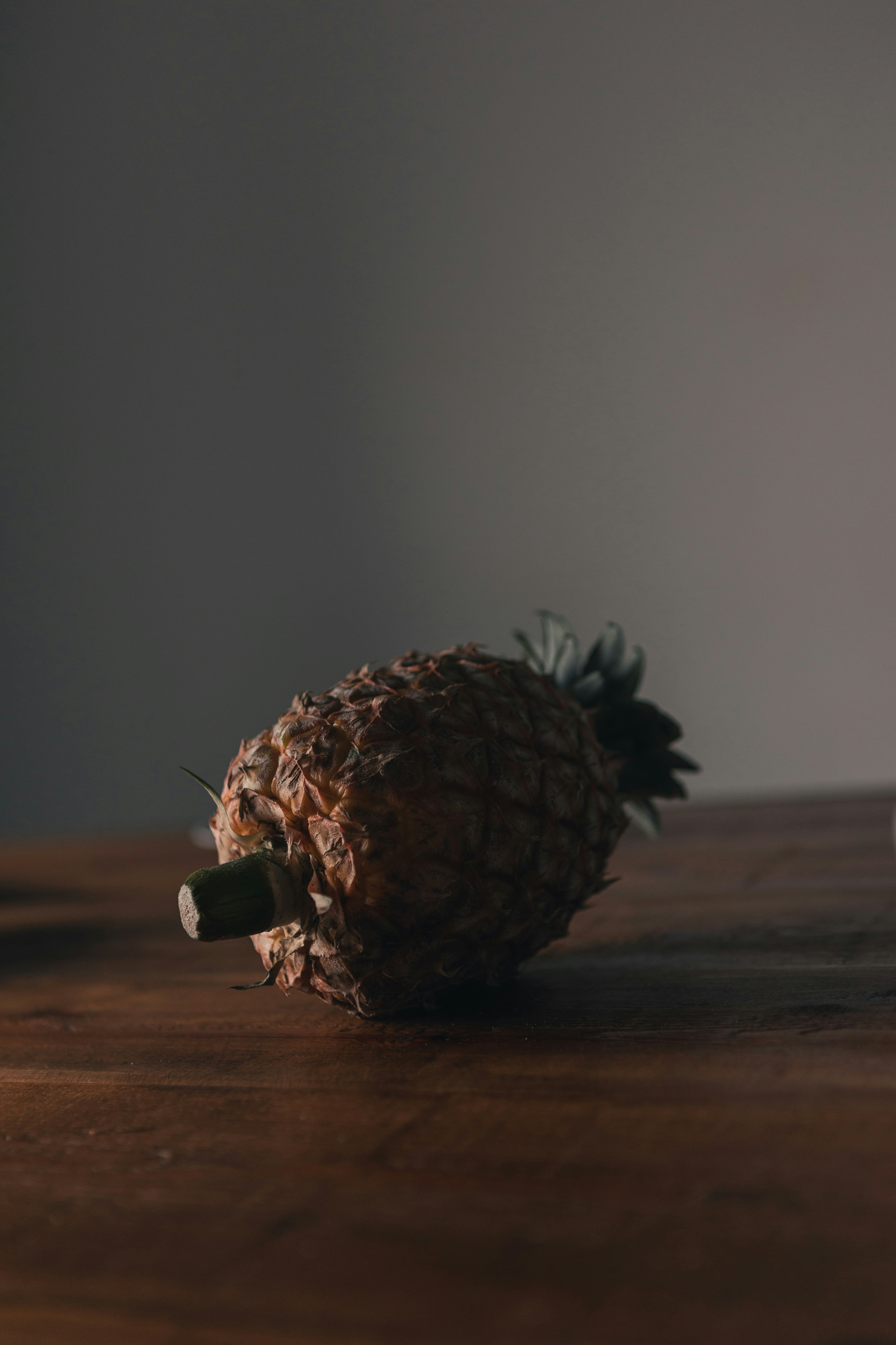 Pineapple in a Quiet, Shallow Light on Weathered Wood