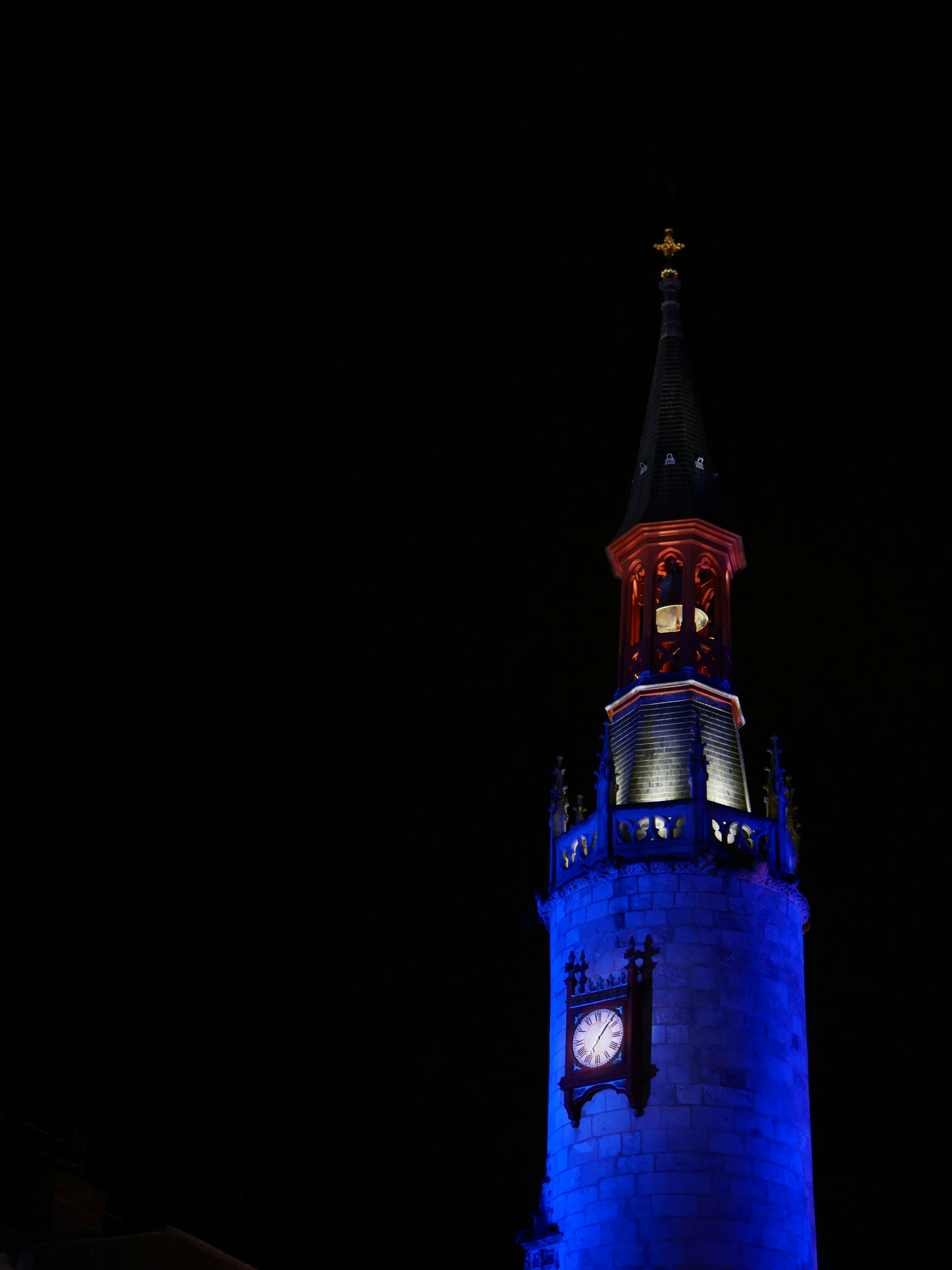 Azure Spire at Midnight: a Night Clocktower Bathed in Blue and Red