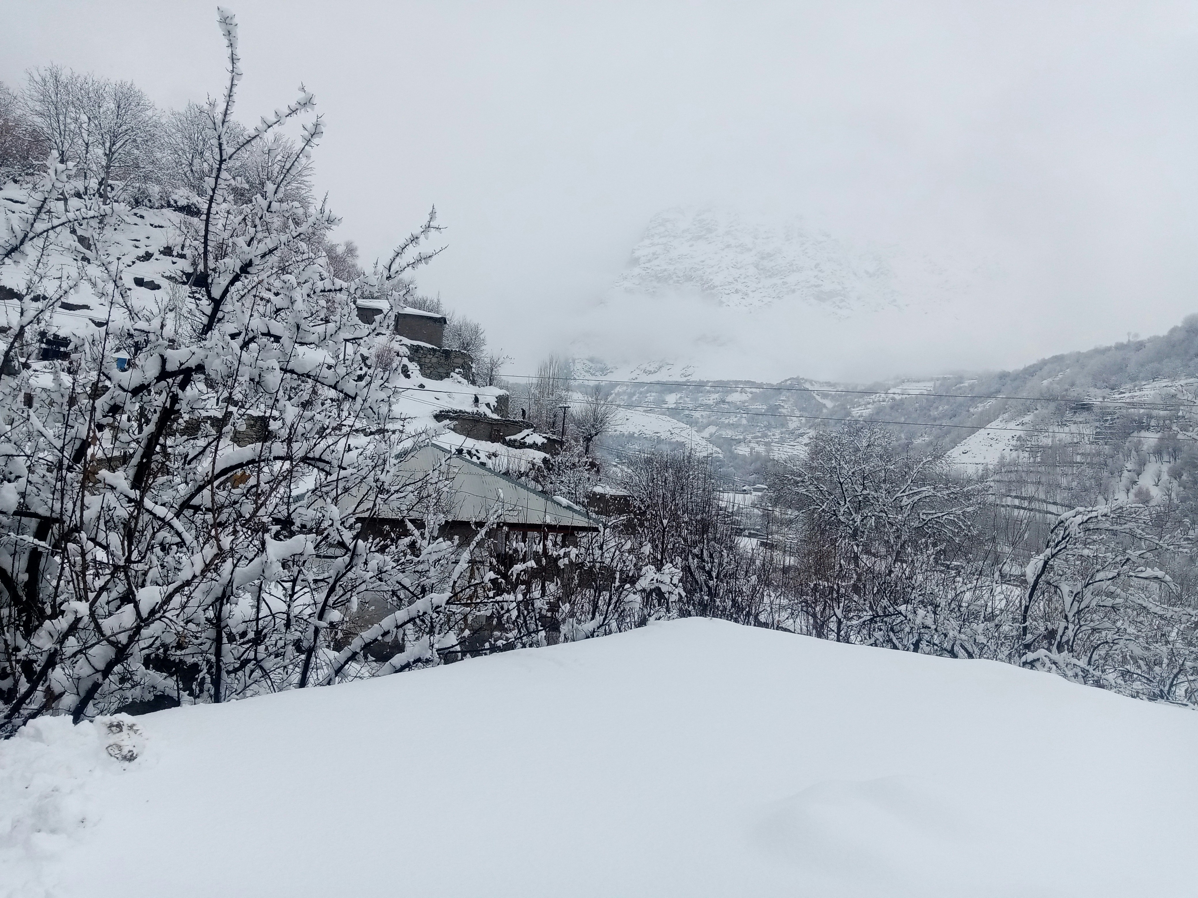 A snow covered hillside with houses in the distance photo – Free Nature ...