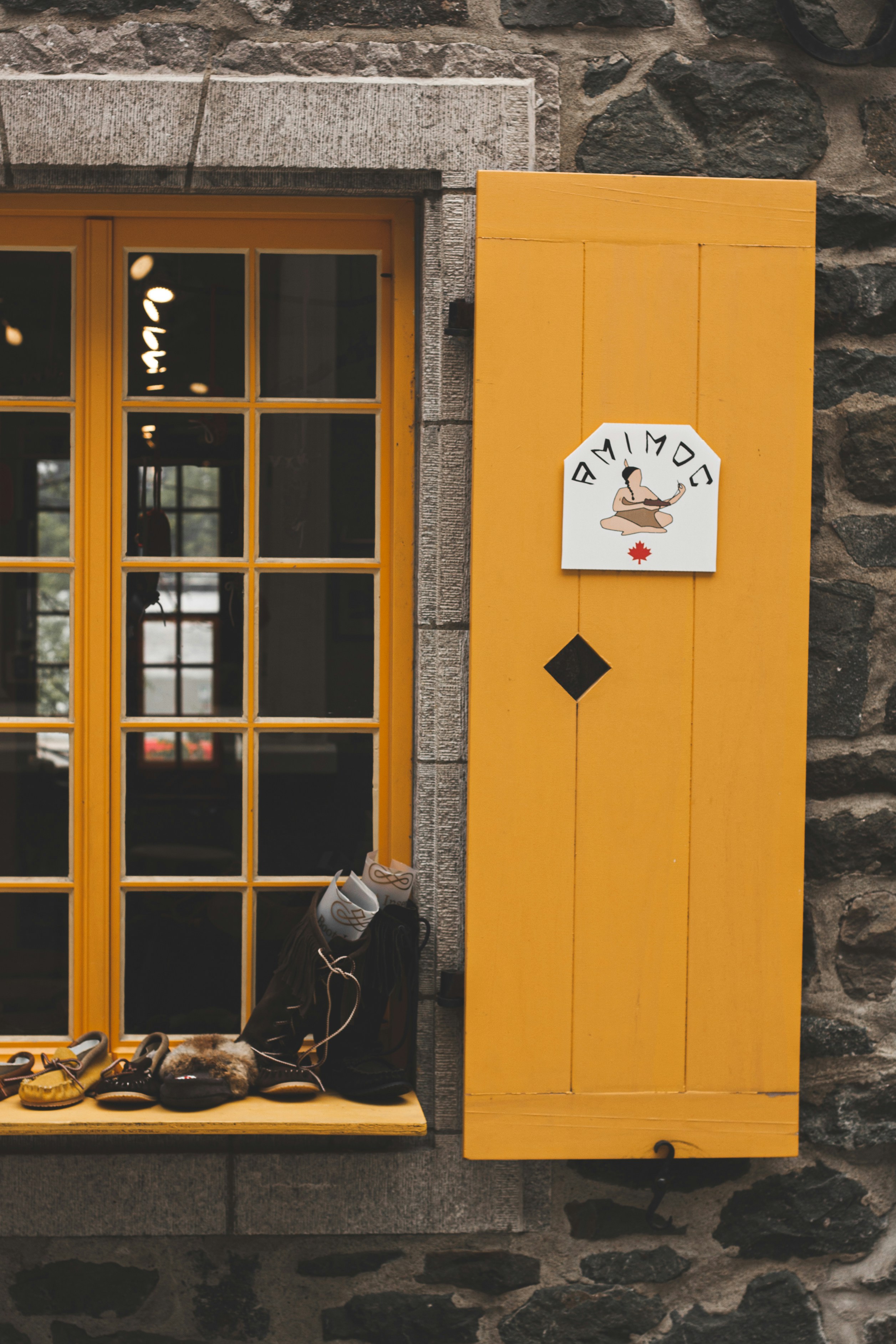 Golden Shuttered Shopfront: Shoes Rest by a Bright Logo Plaque