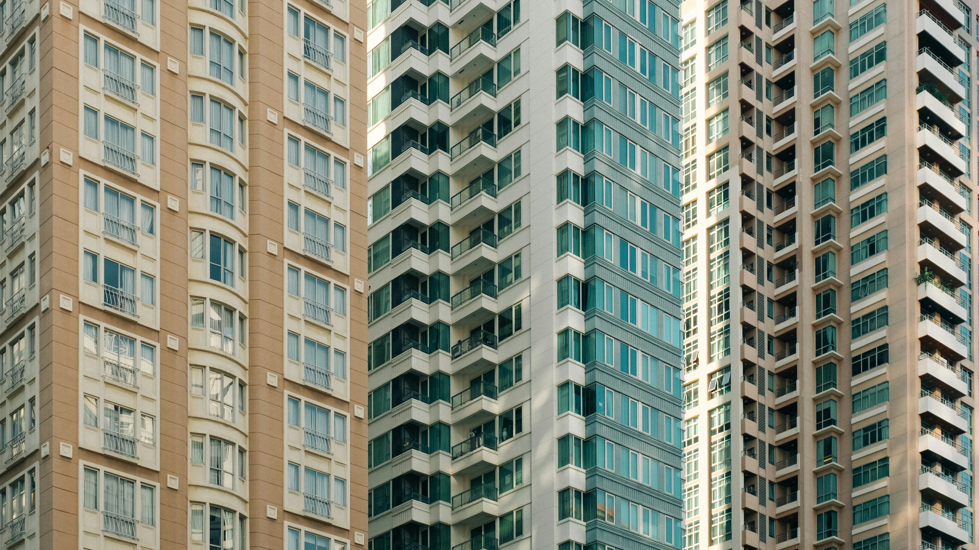 A close-up view of a cluster of high-rise buildings showcasing diverse architectural styles and materials. The interplay of glass and concrete highlights modern urban design.