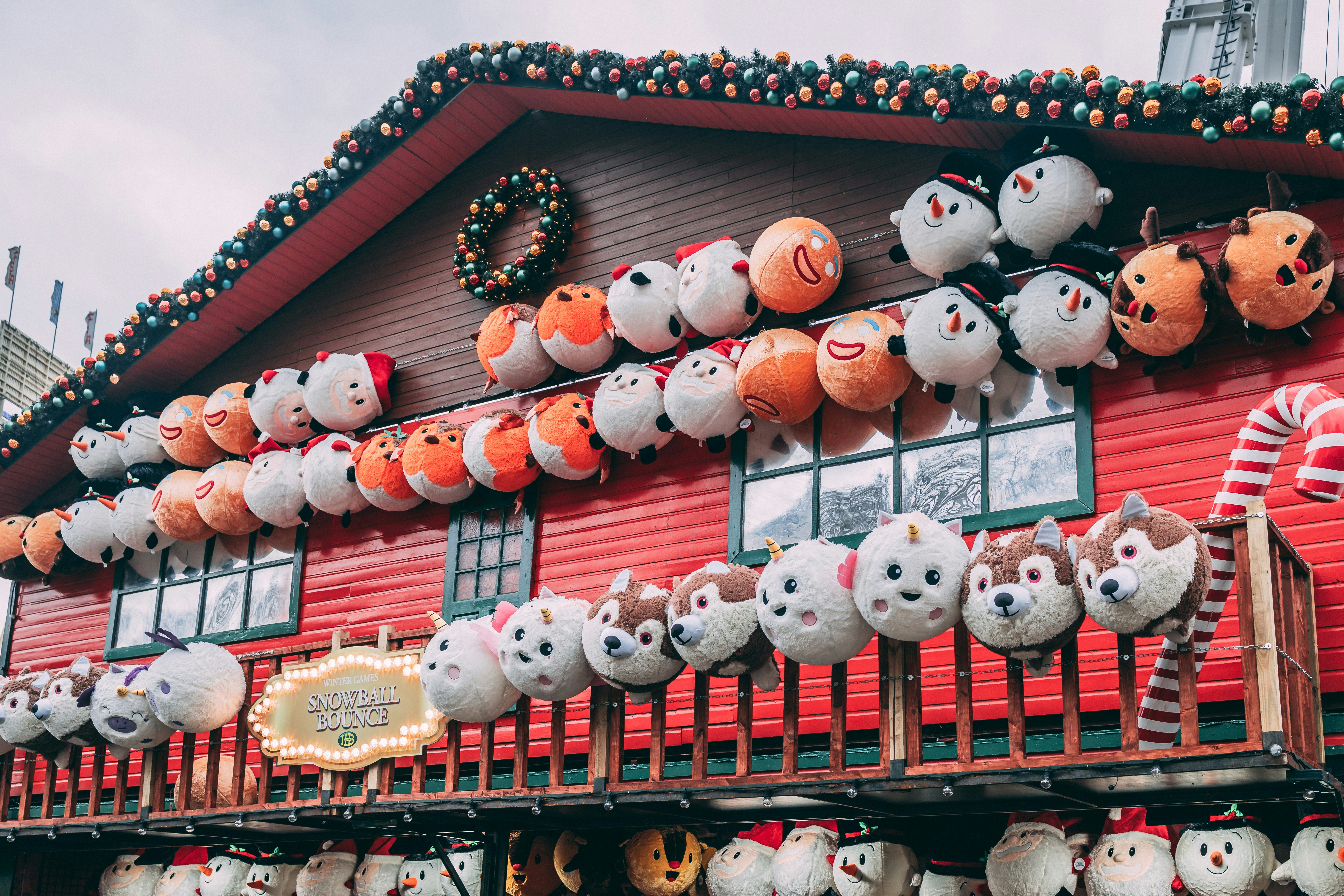 Colorful, plush animal decorations adorn a festive cabin, showcasing a charming holiday spirit. The vibrant display invites joy and nostalgia.