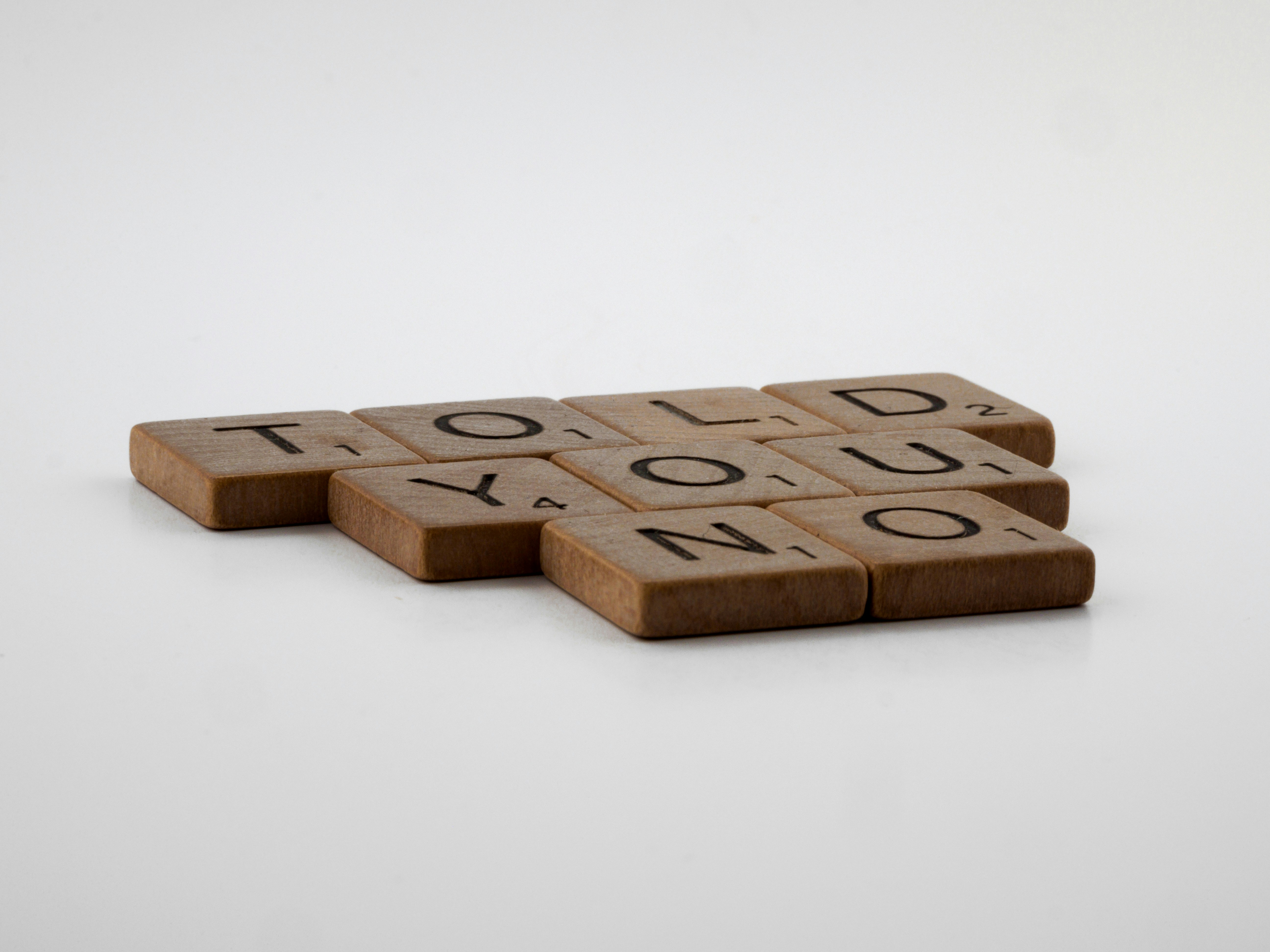 Scrabble tiles arranged to spell 'TOLD YOU NO' against a clean white background.