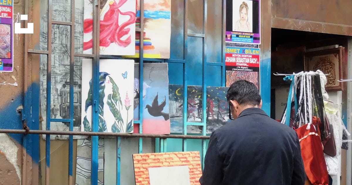 Un Homme Debout à Côté Dune Table En Bois Devant Un Magasin Photo
