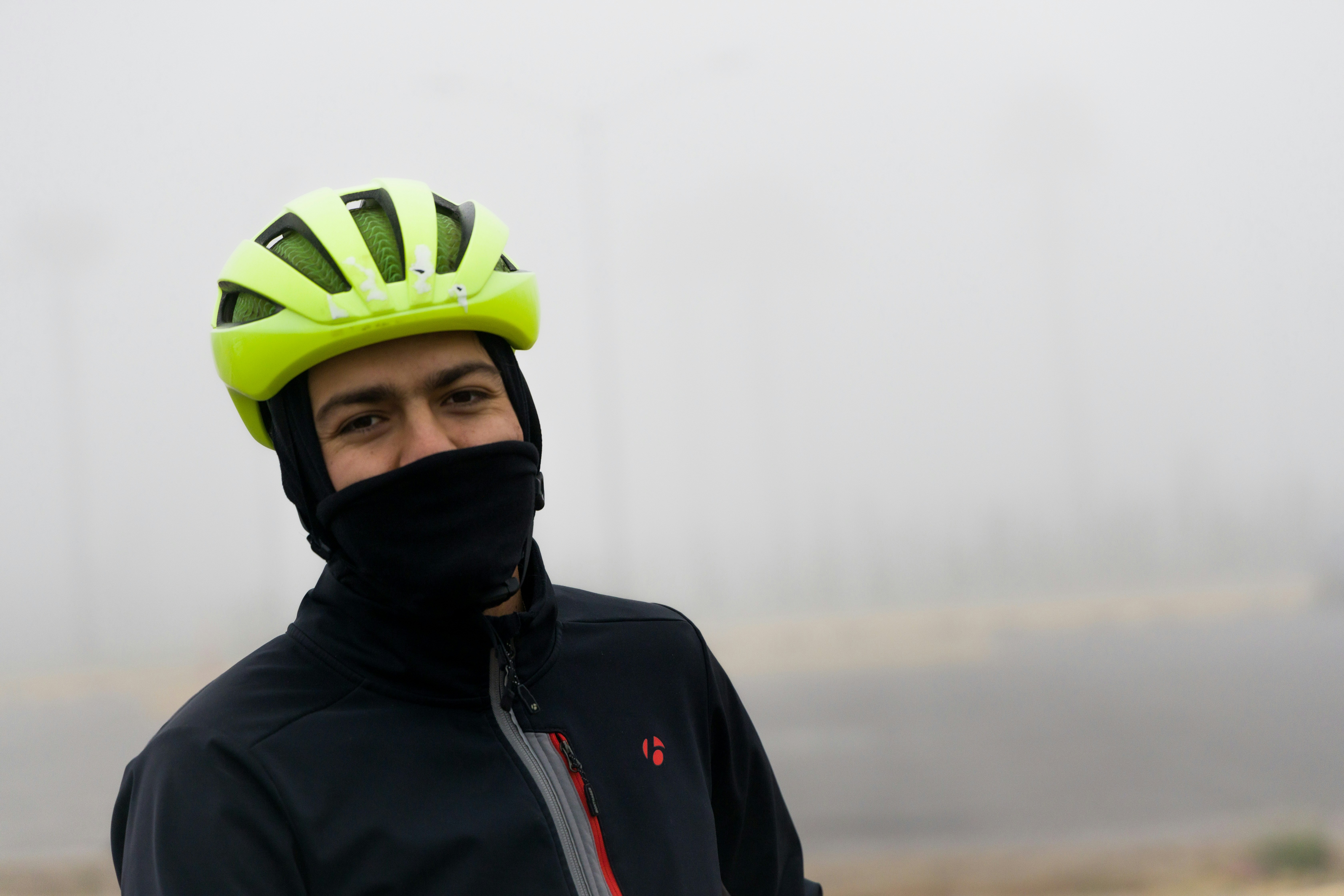Lone Cyclist in the Fog: Neon Helmet Illuminates the Mist