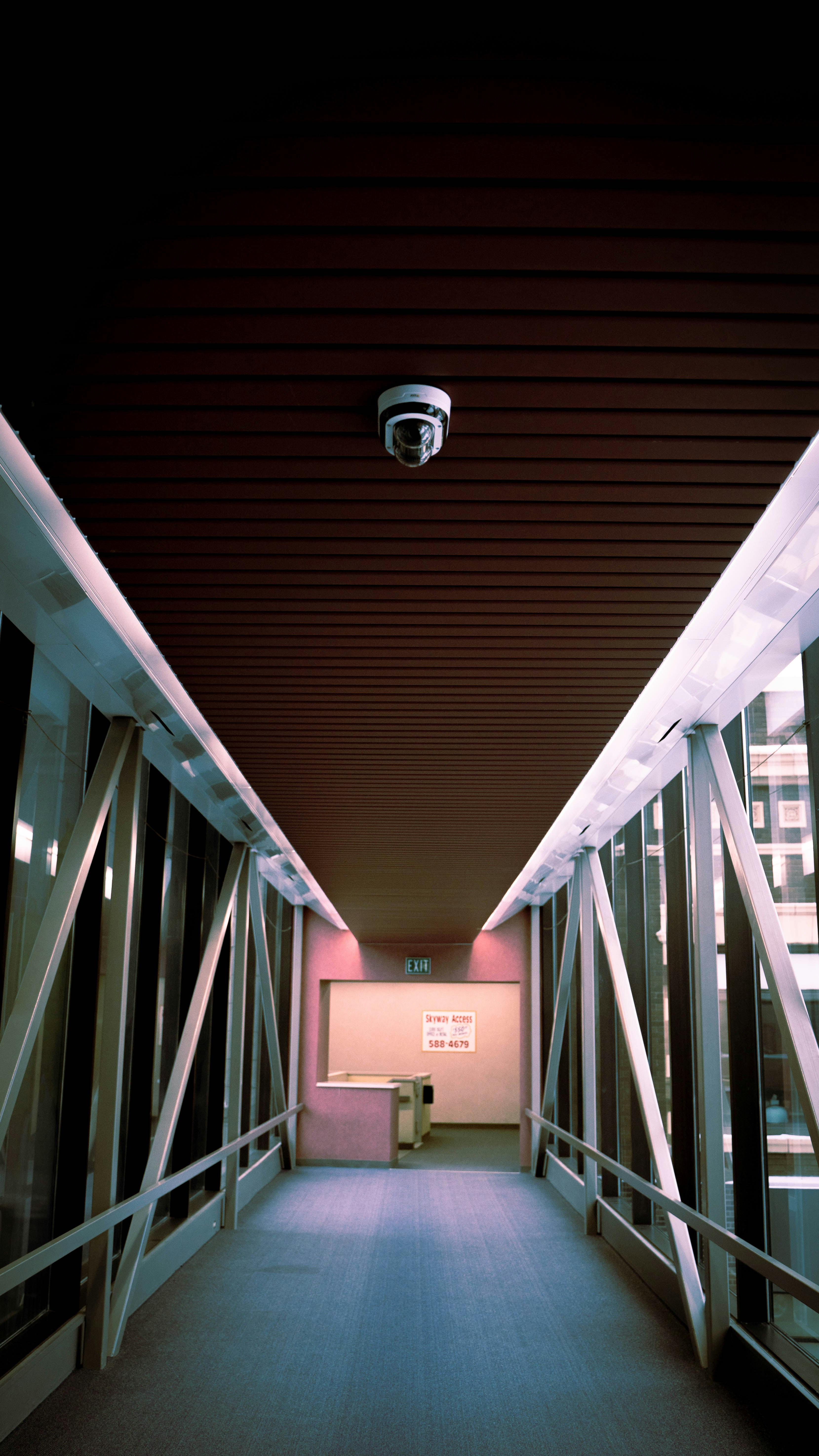 A long hallway with metal railings and a ceiling light photo – Free ...
