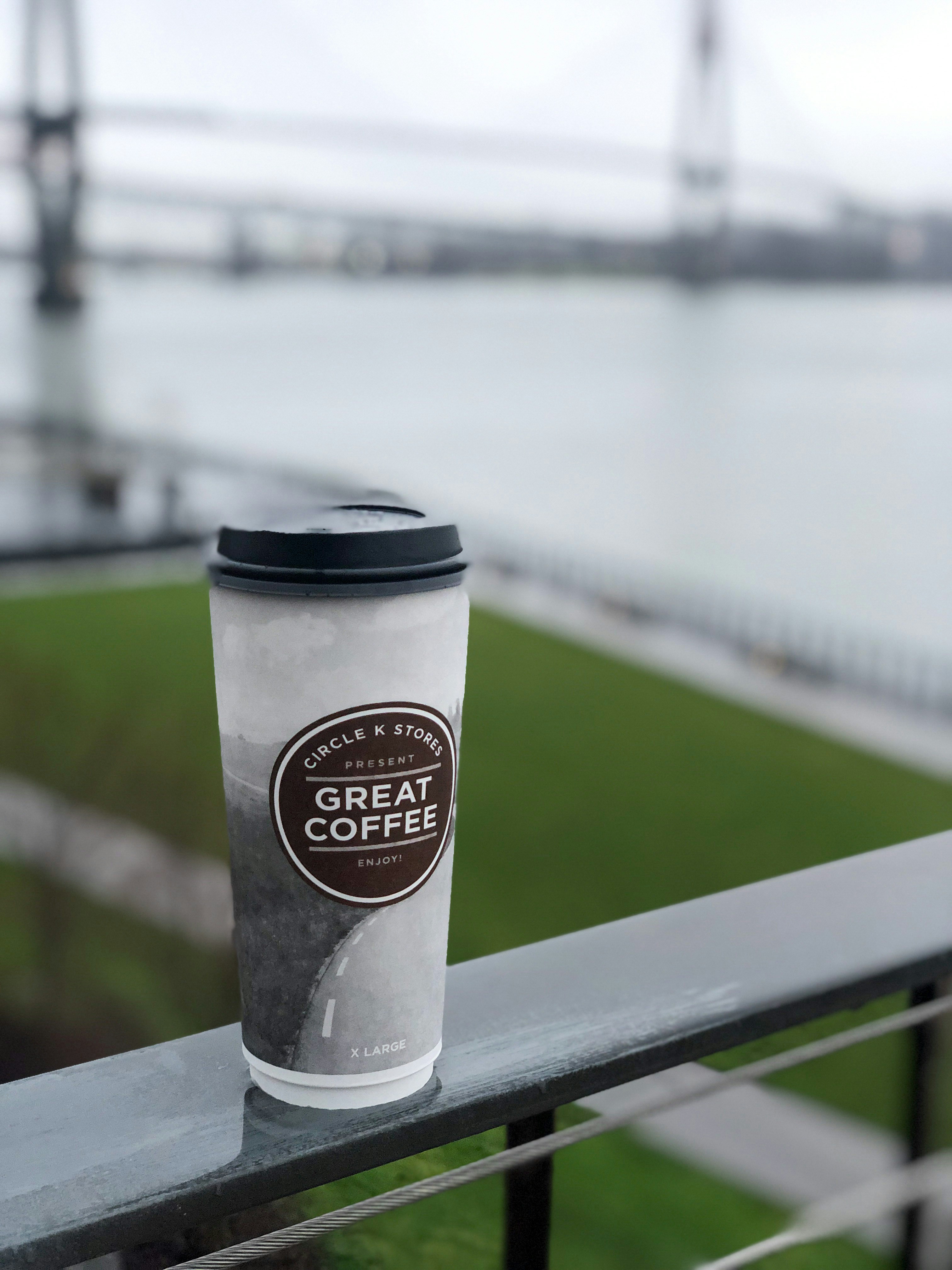 Coffee on the Rail: A Quiet Moment Over the Riverfront Bridge