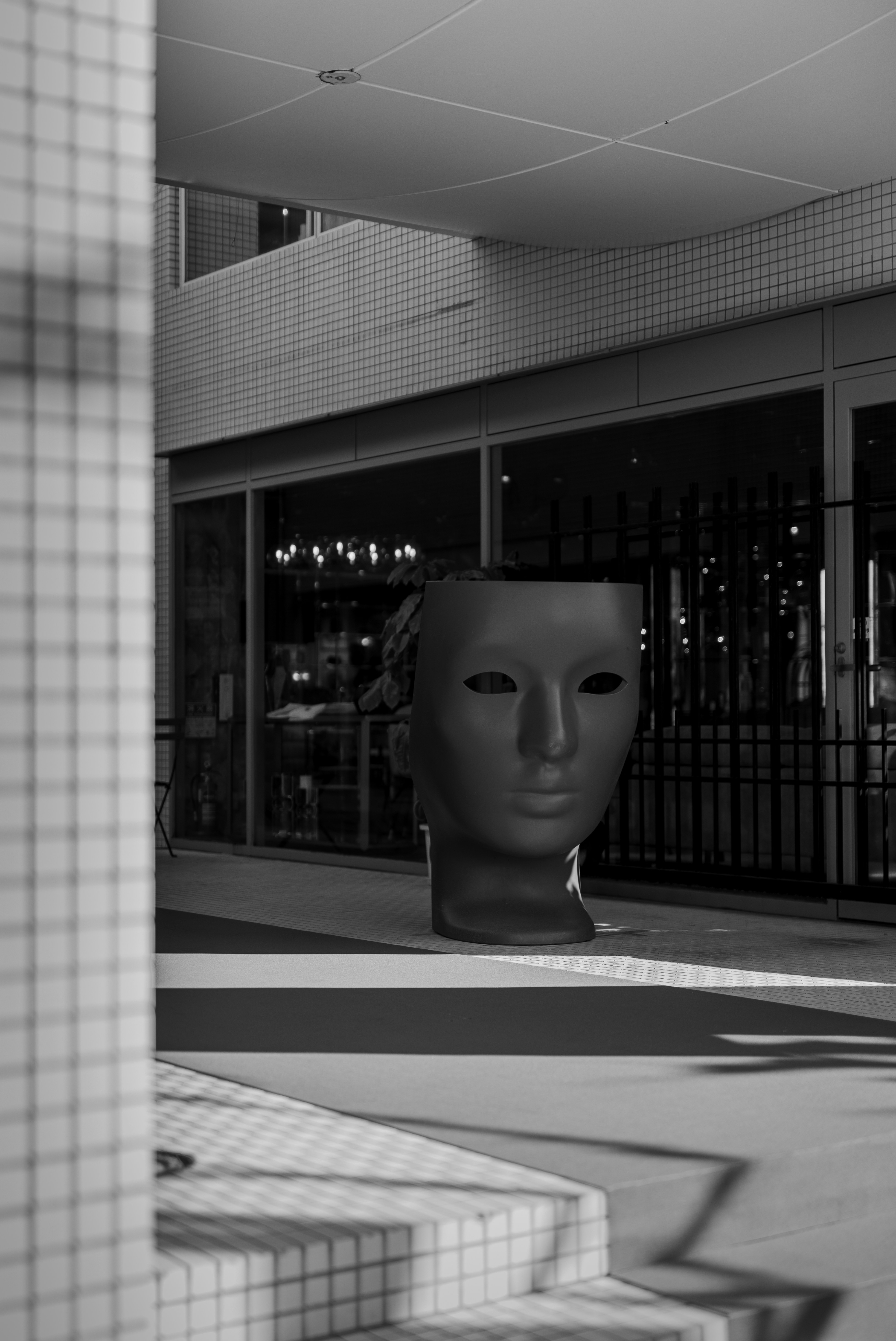 Monochrome Mask in a Tile-Tiled Atrium