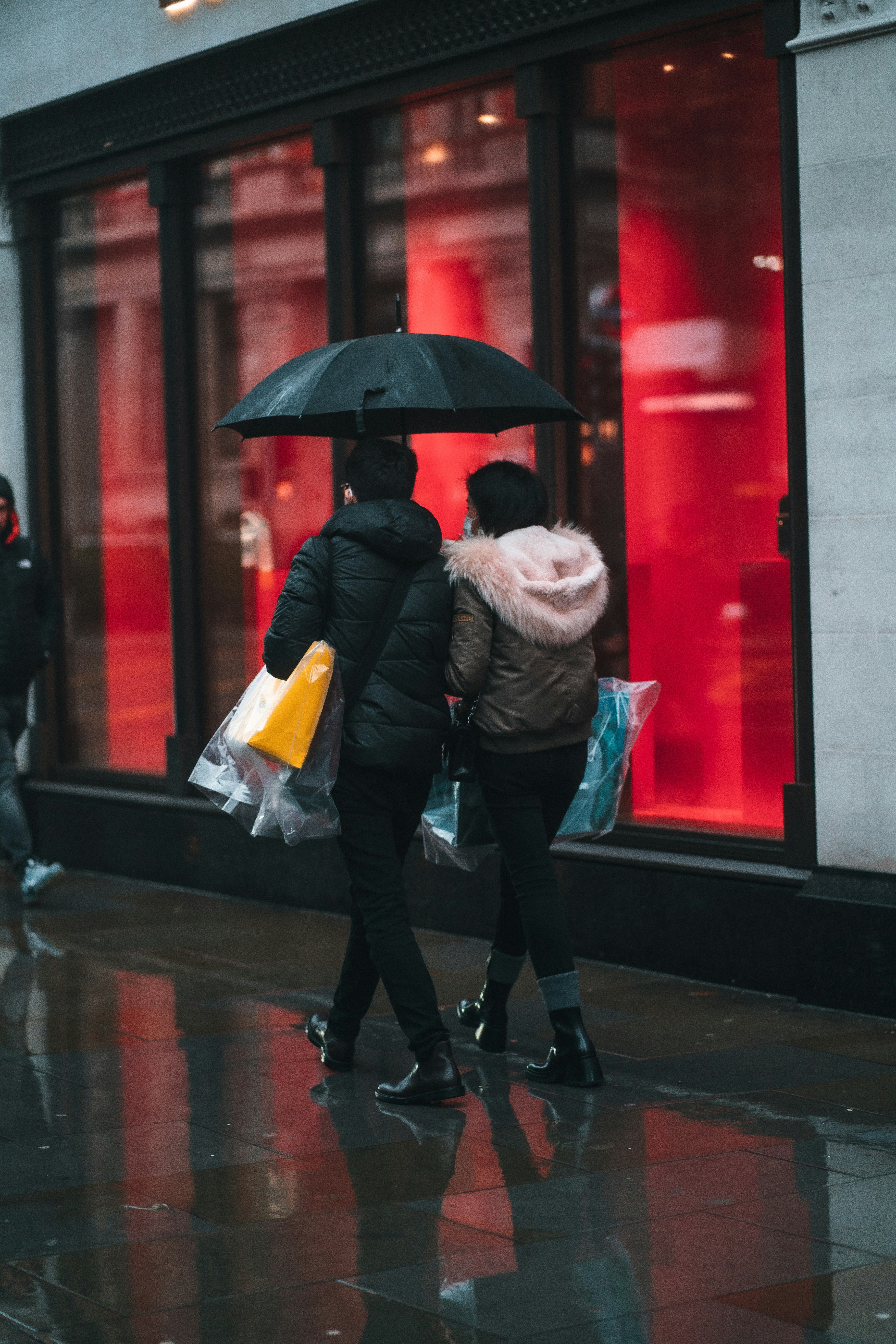 a couple of people walking down a street holding umbrellas