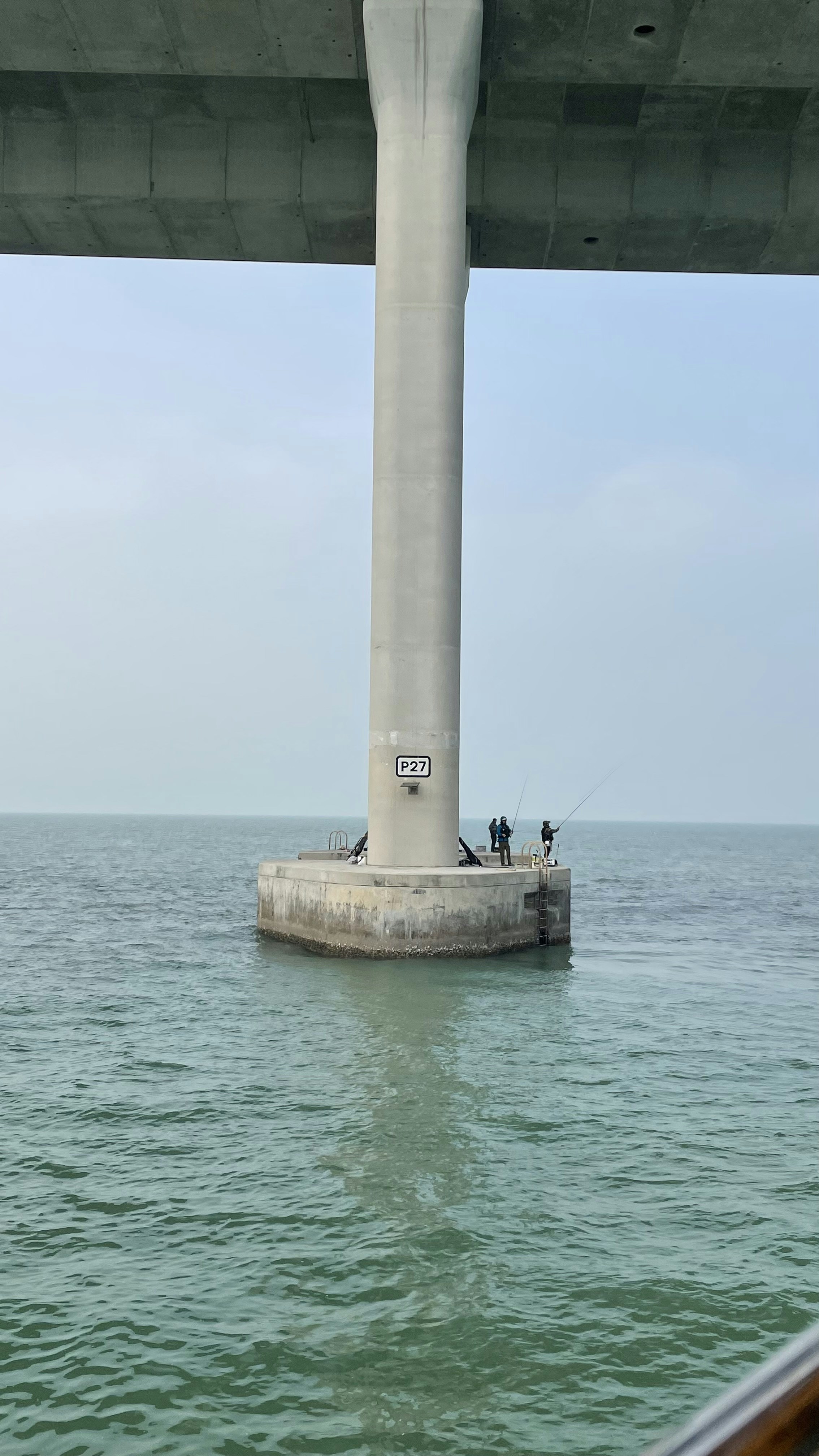 a view of the ocean from under a bridge