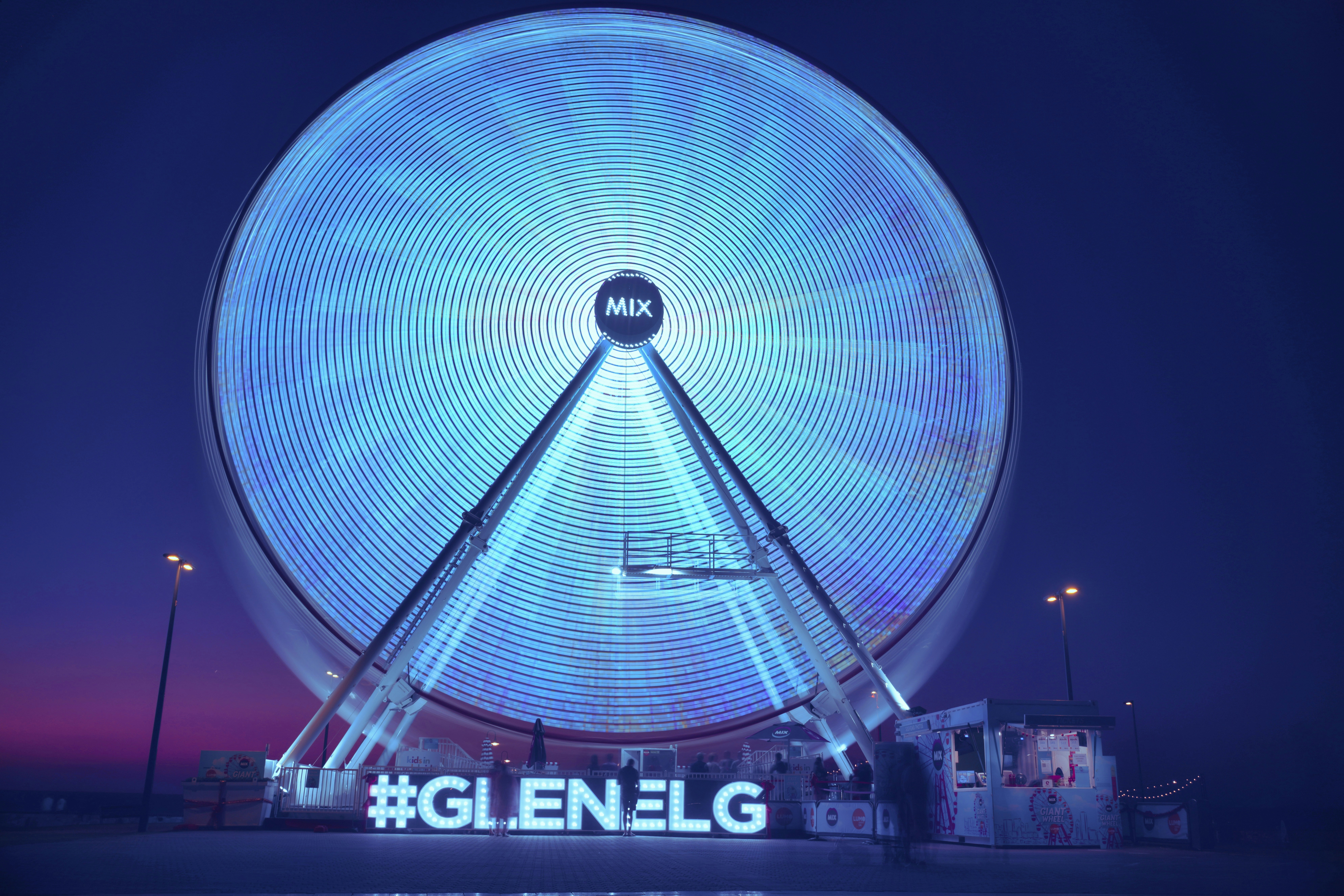 A ferris wheel lit up at night with the word glief on it photo – Free ...