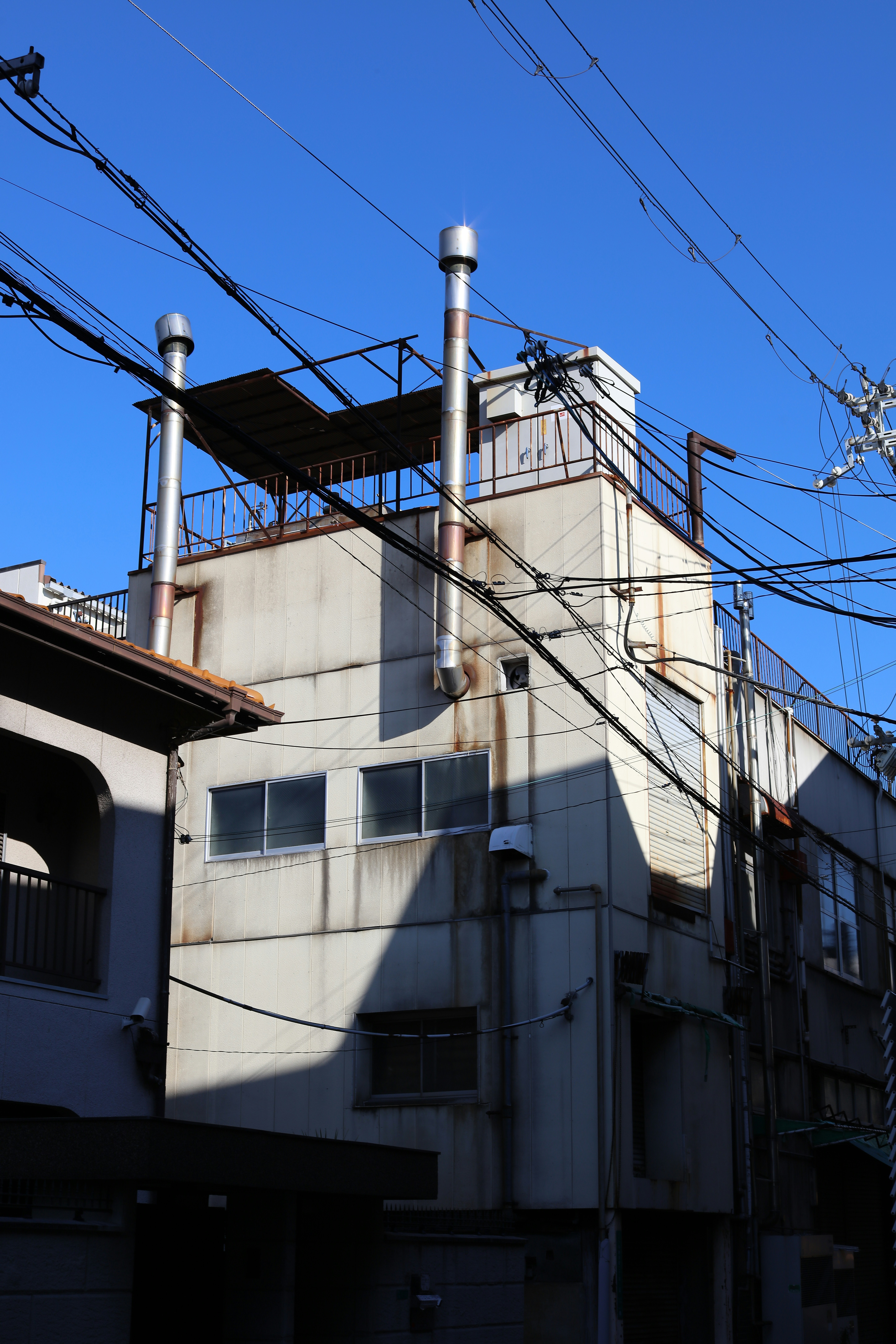 Rooftop Lattice: Quiet Towers and Electric Threads Against a Cerulean Sky