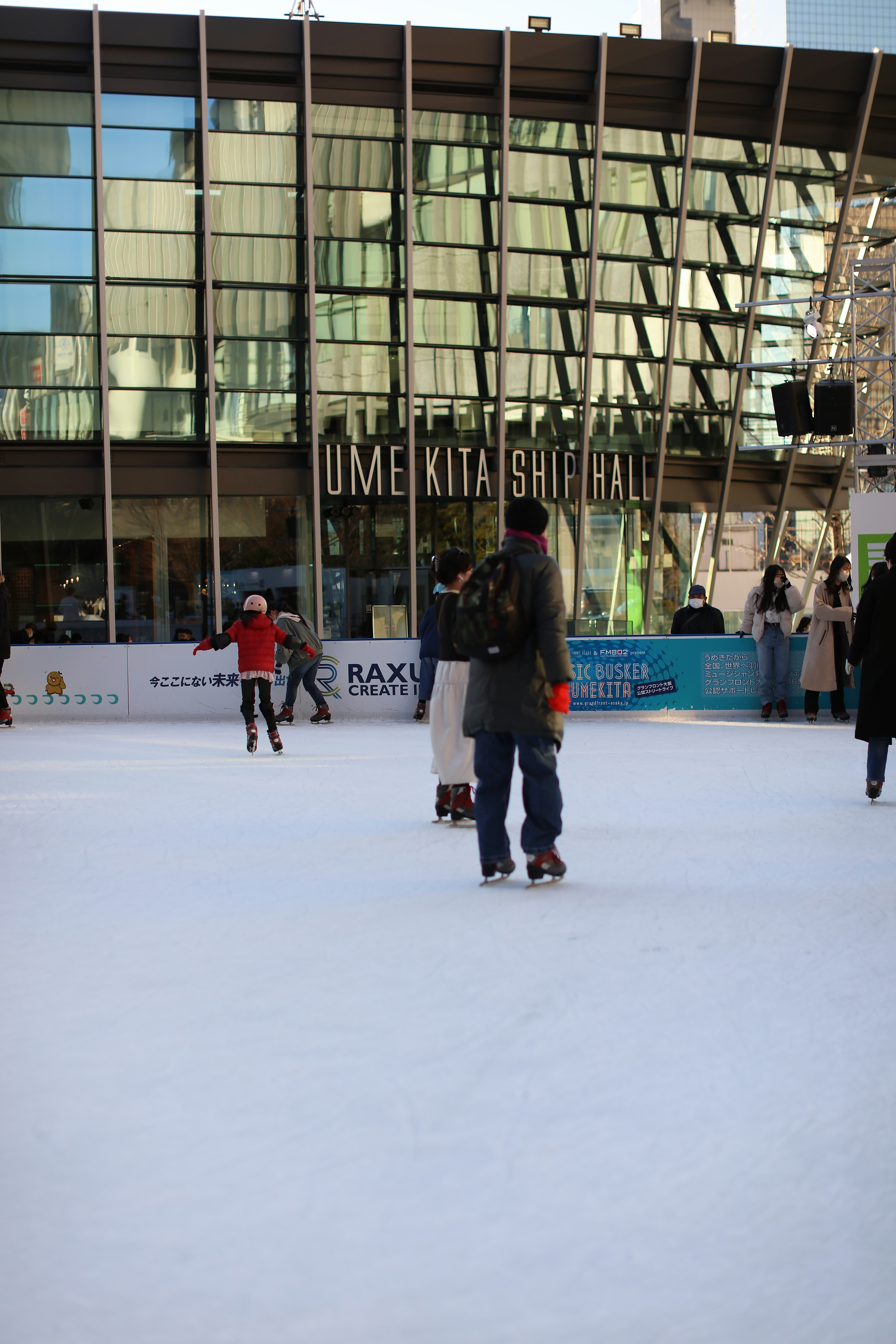 Glass Facade Rink: Skaters in Front of a Modern Hall