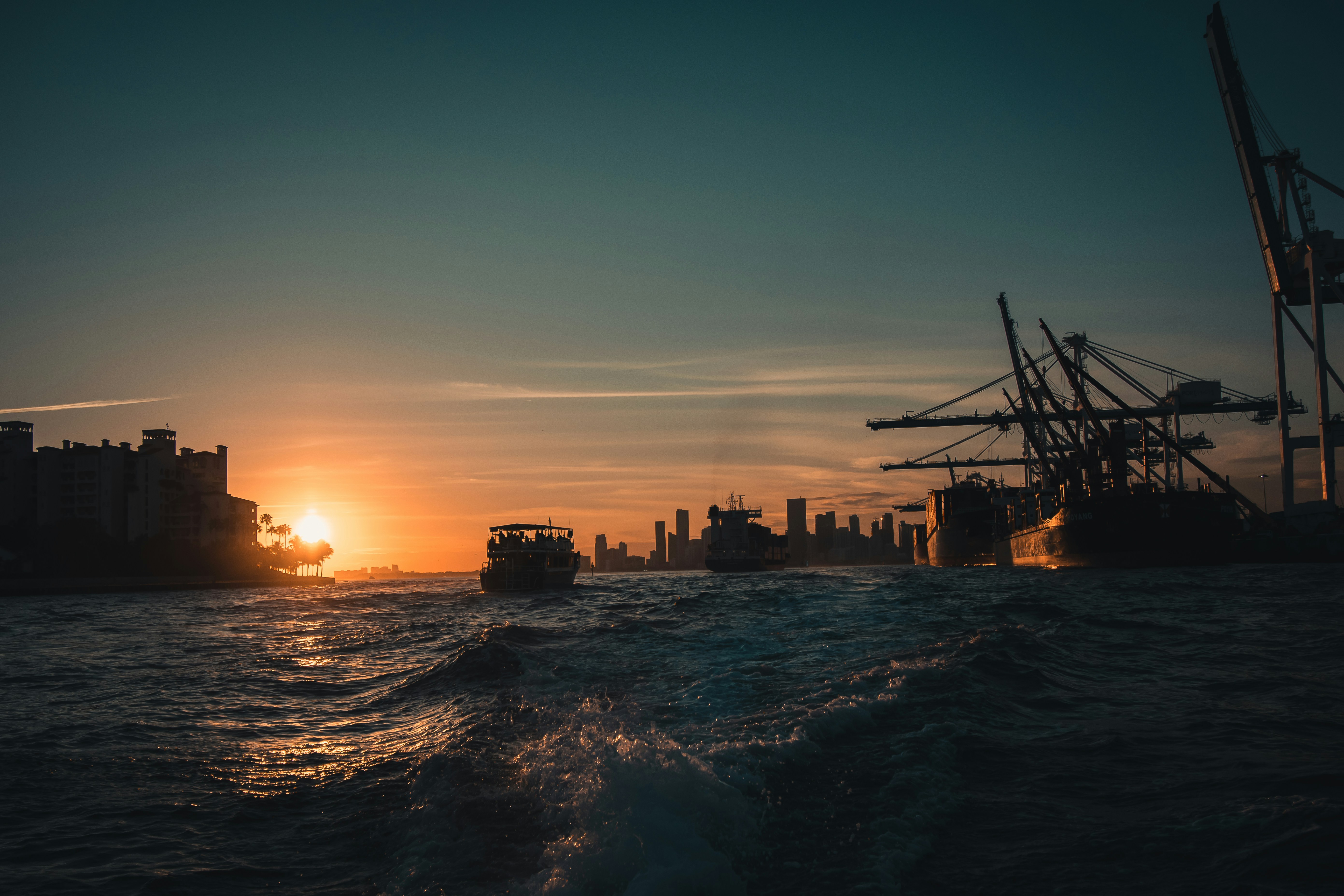 The sun is setting over a large body of water photo – Free Miami Image ...