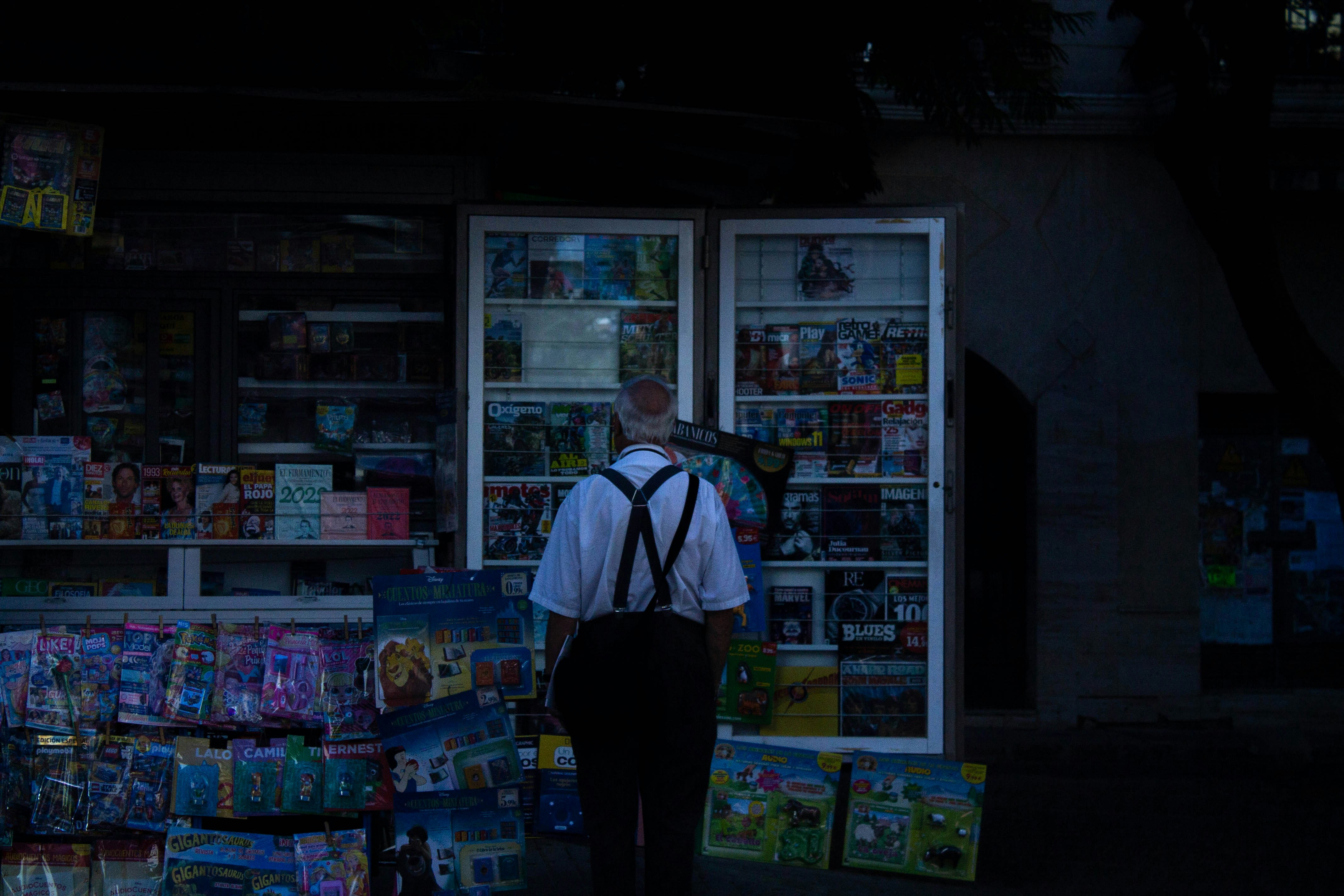 A man standing in front of a store at night photo – Free Human Image on ...