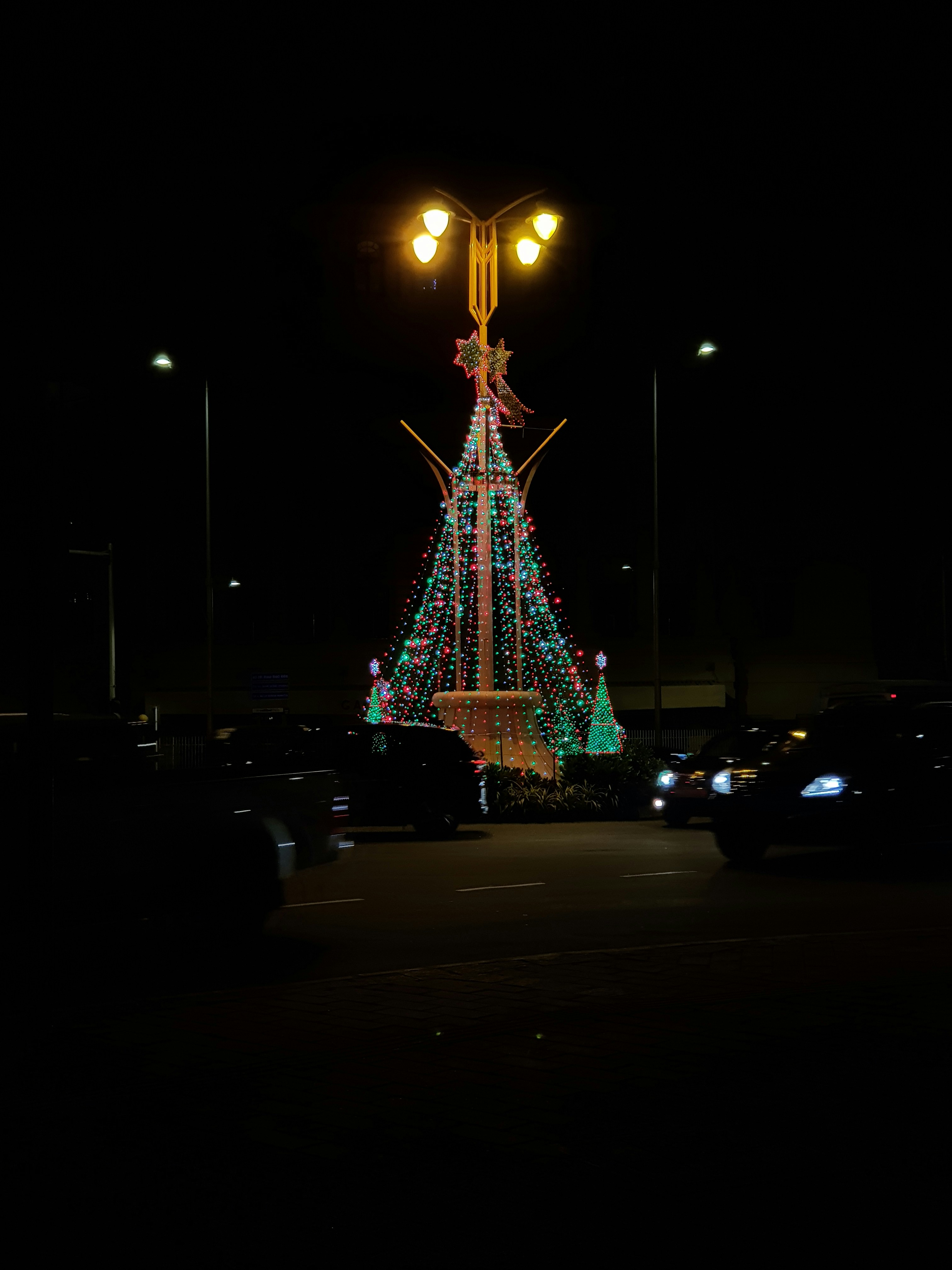 A lighted christmas tree in the middle of a parking lot photo – Free ...