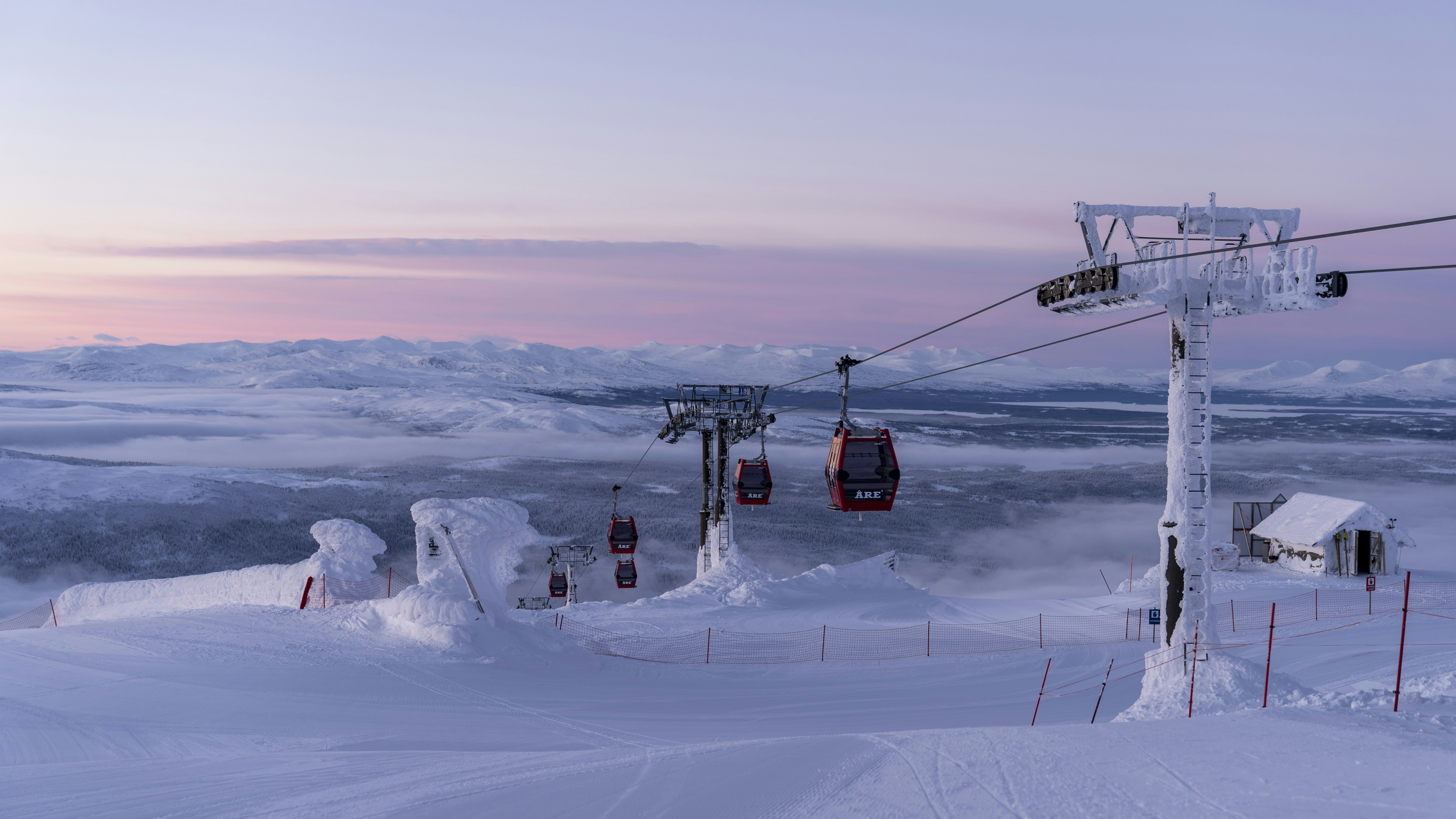 Sunrise views from Åreskutan.  | a ski lift going over a snow covered mountain
