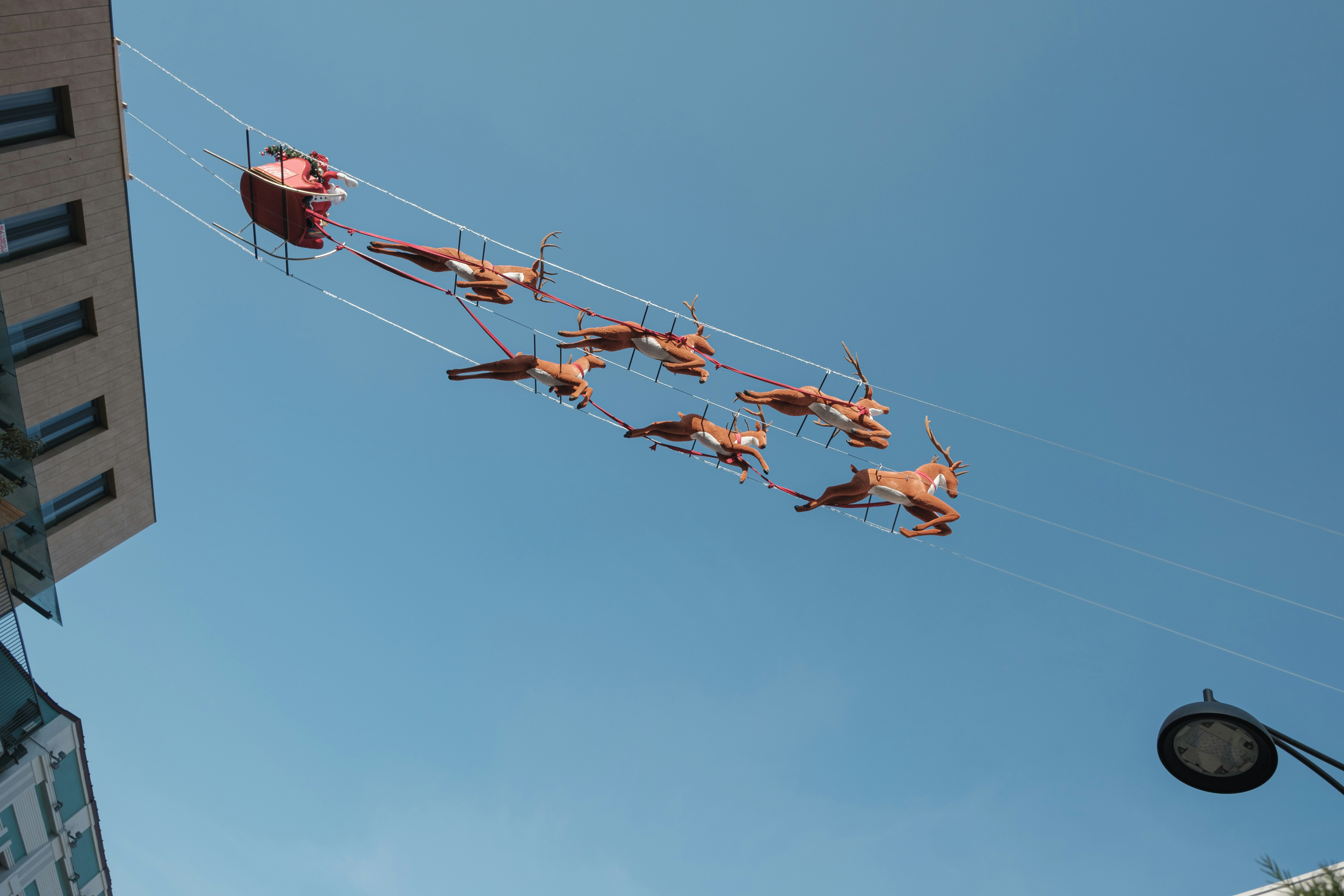 Skyline Wirewalk: Aerial Figures Traverse a City Cable Under a Clear Day