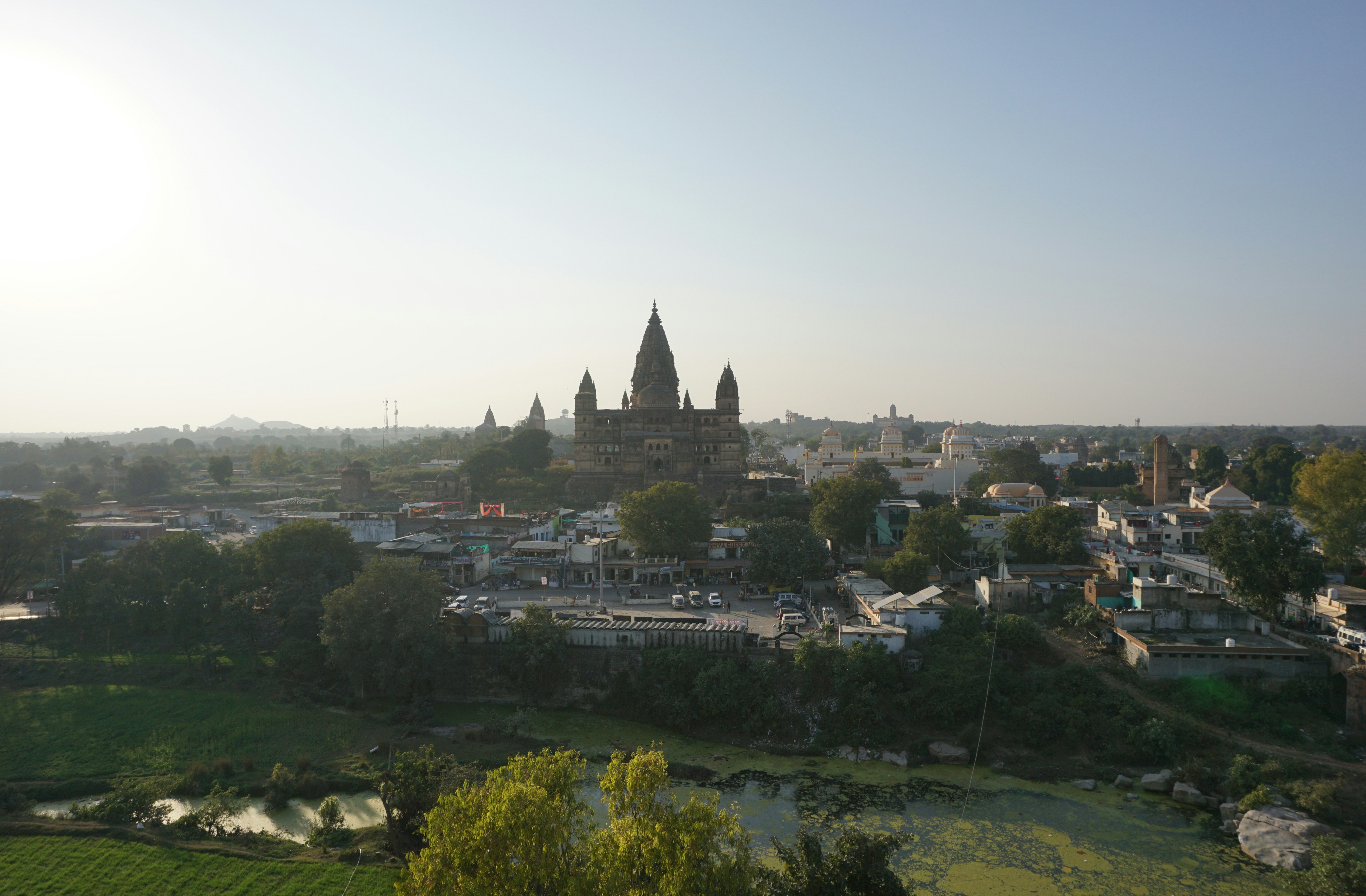 Sunlit Temple Silhouette Over a Quiet River Town