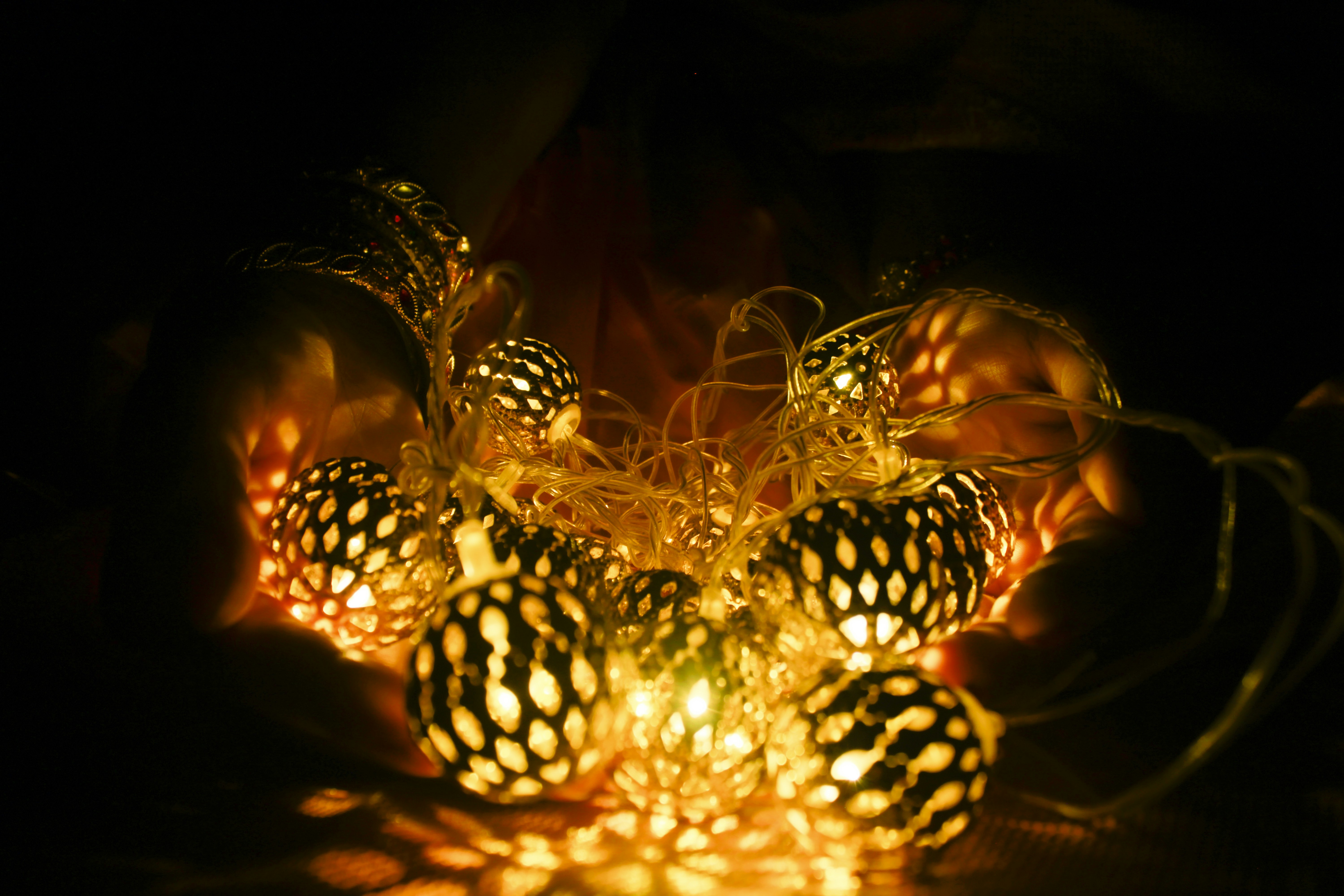 A person holding a string of lights in their hands photo – Free Light ...