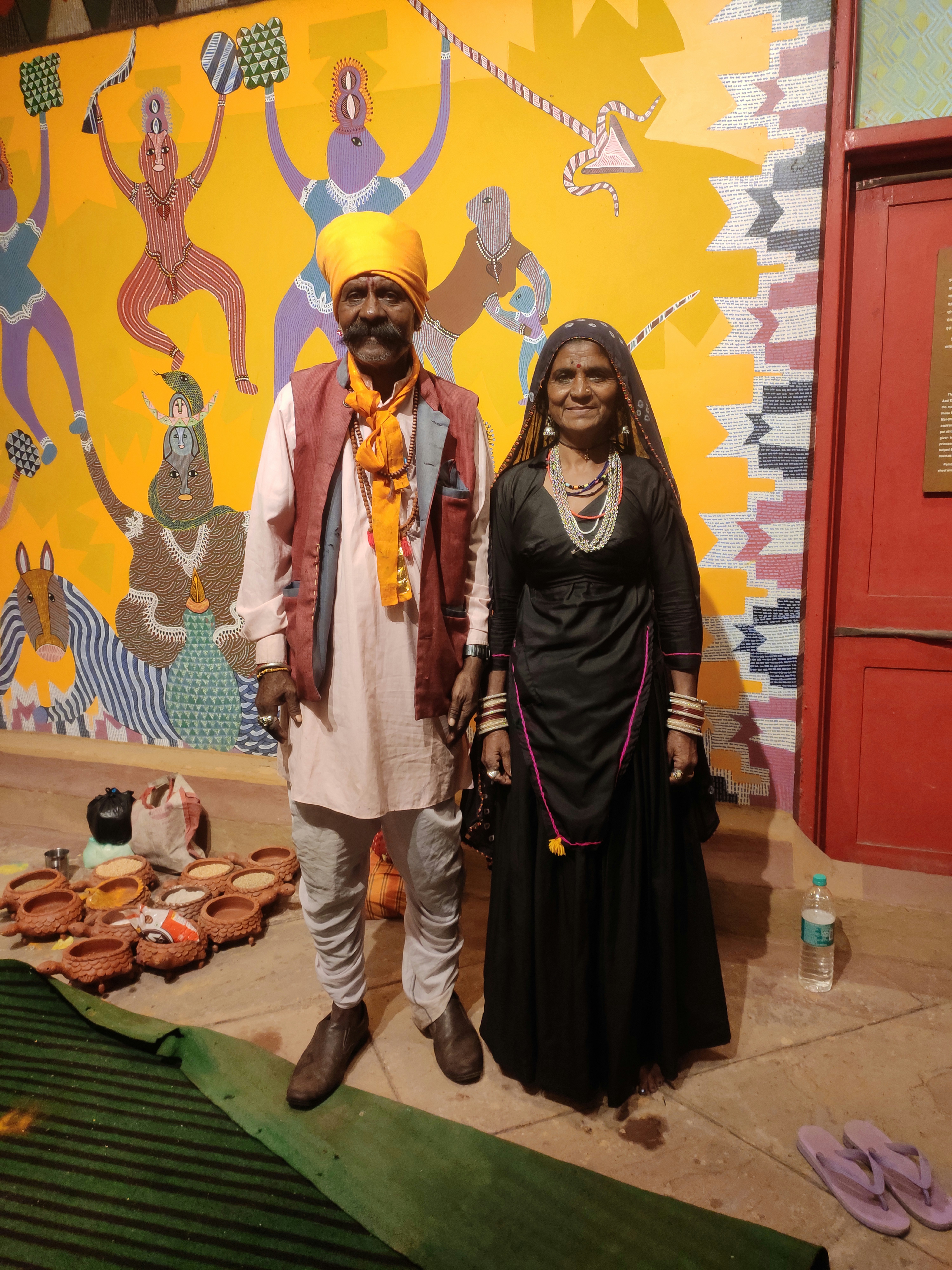 Colorful Encounter: A Turbaned Gentleman and Beaded Lady Before a Bold Indian Folk-Mural