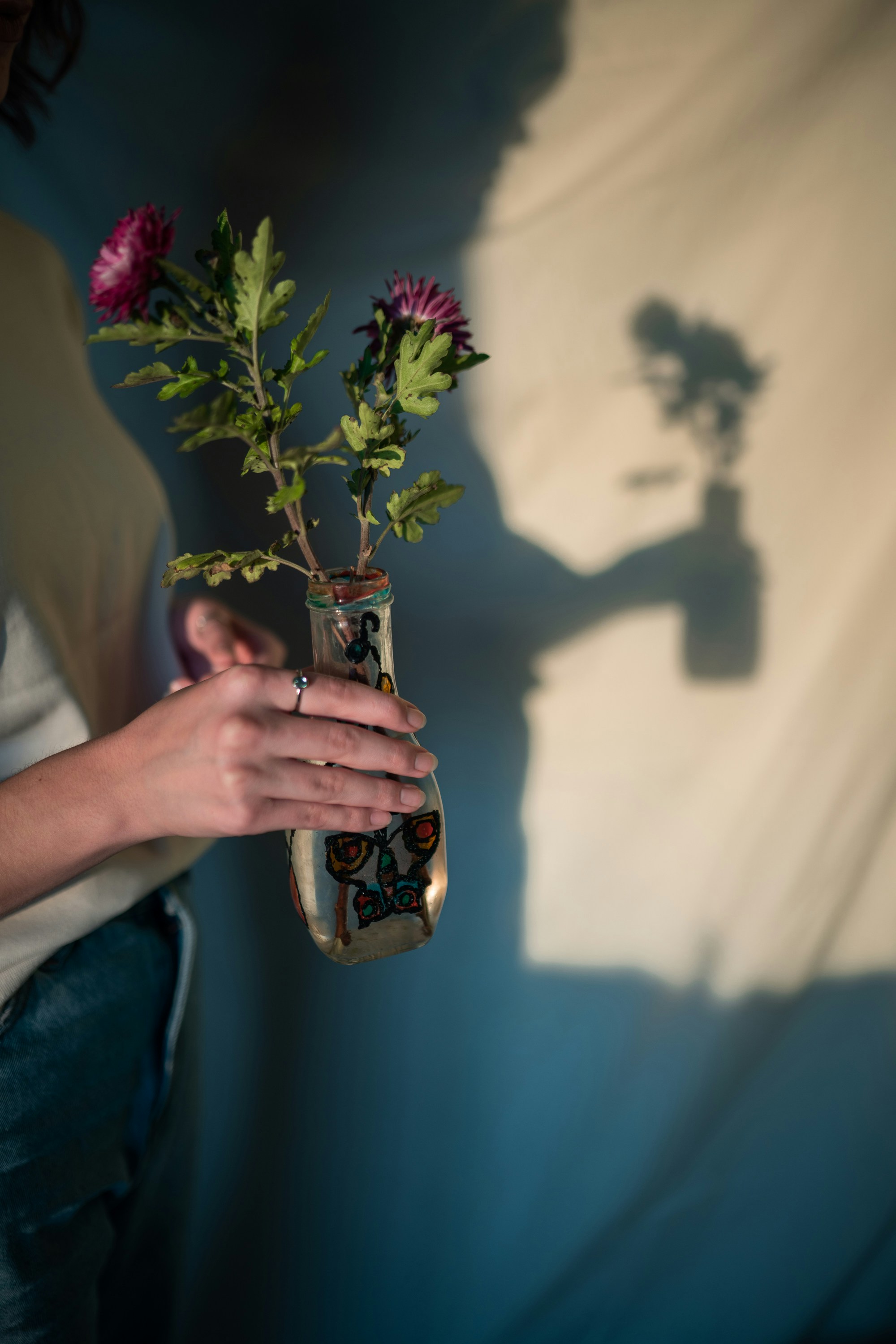 Petals in a Glass Bottle, Handheld Vase Beneath a Quiet Shadow