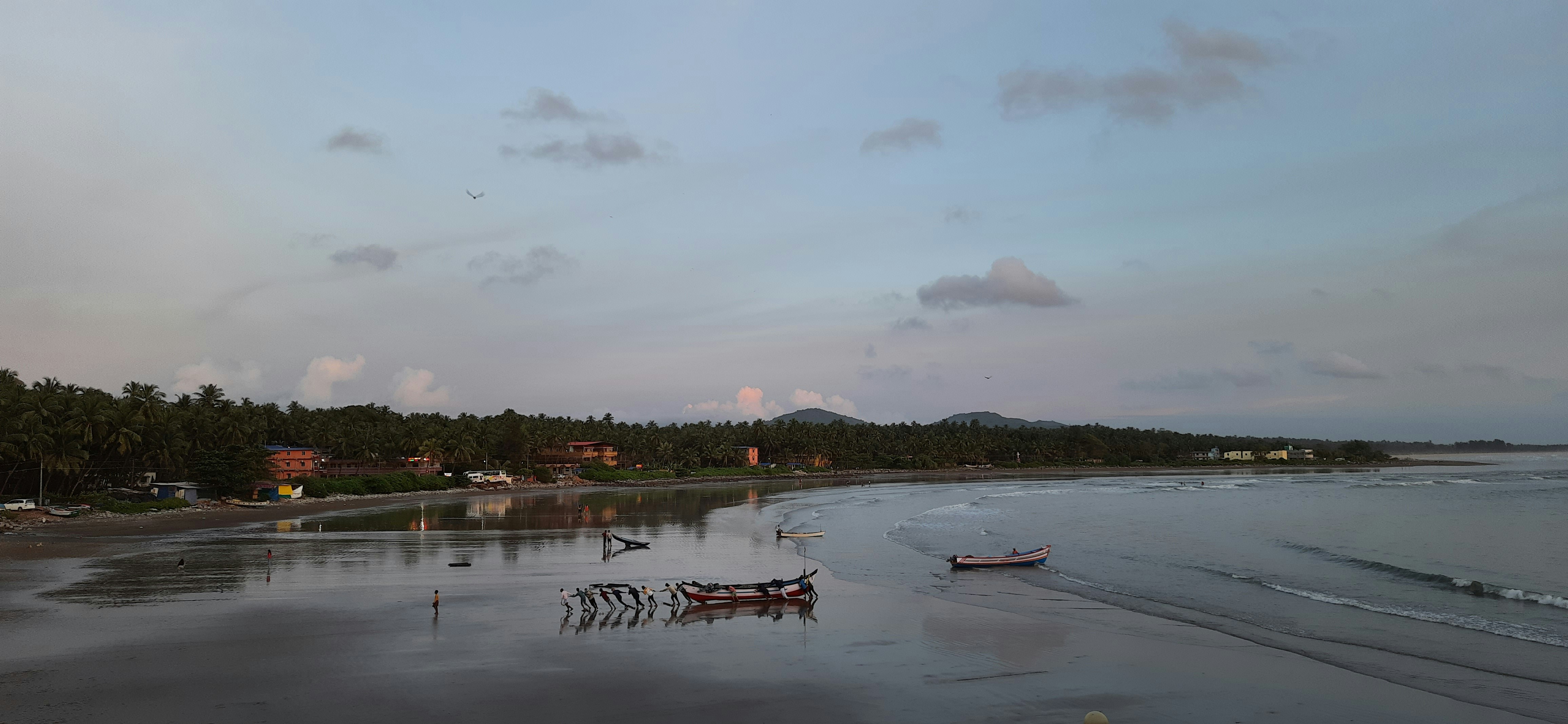 a beach with a few boats in the water