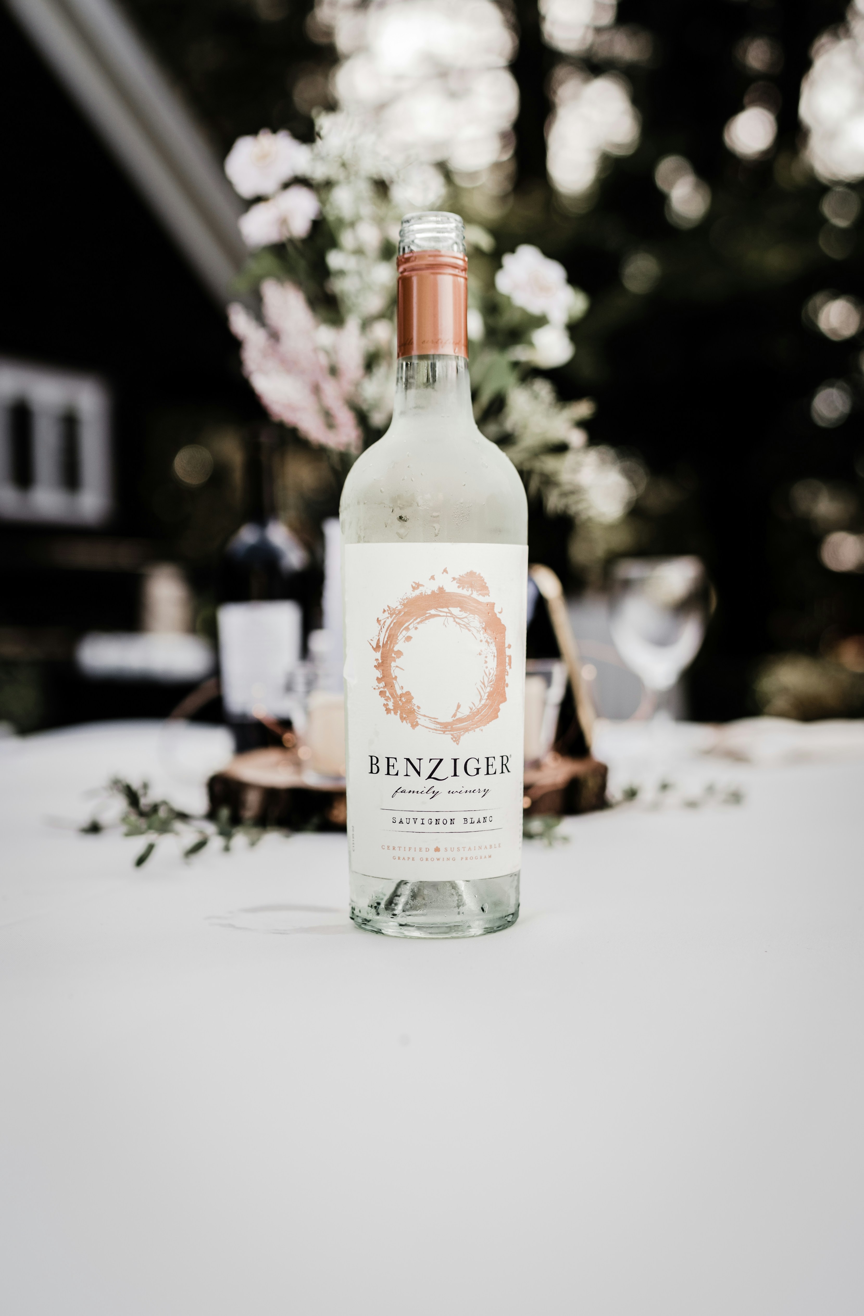 Bottle of Benziger on a Sunlit Table at an Outdoor Gathering