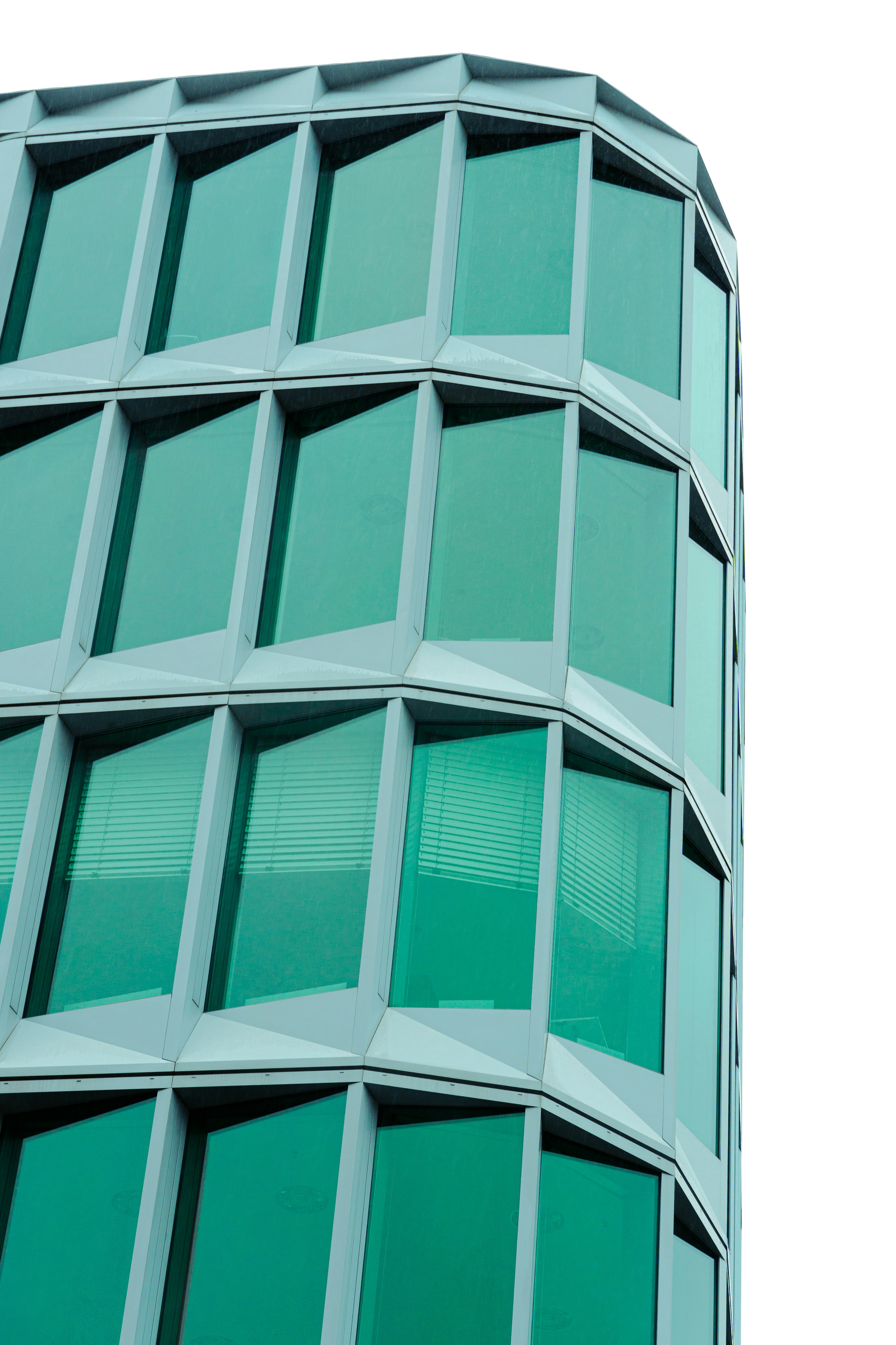 Teal Facade Grid: Geometry Curves Along a Glass Corner