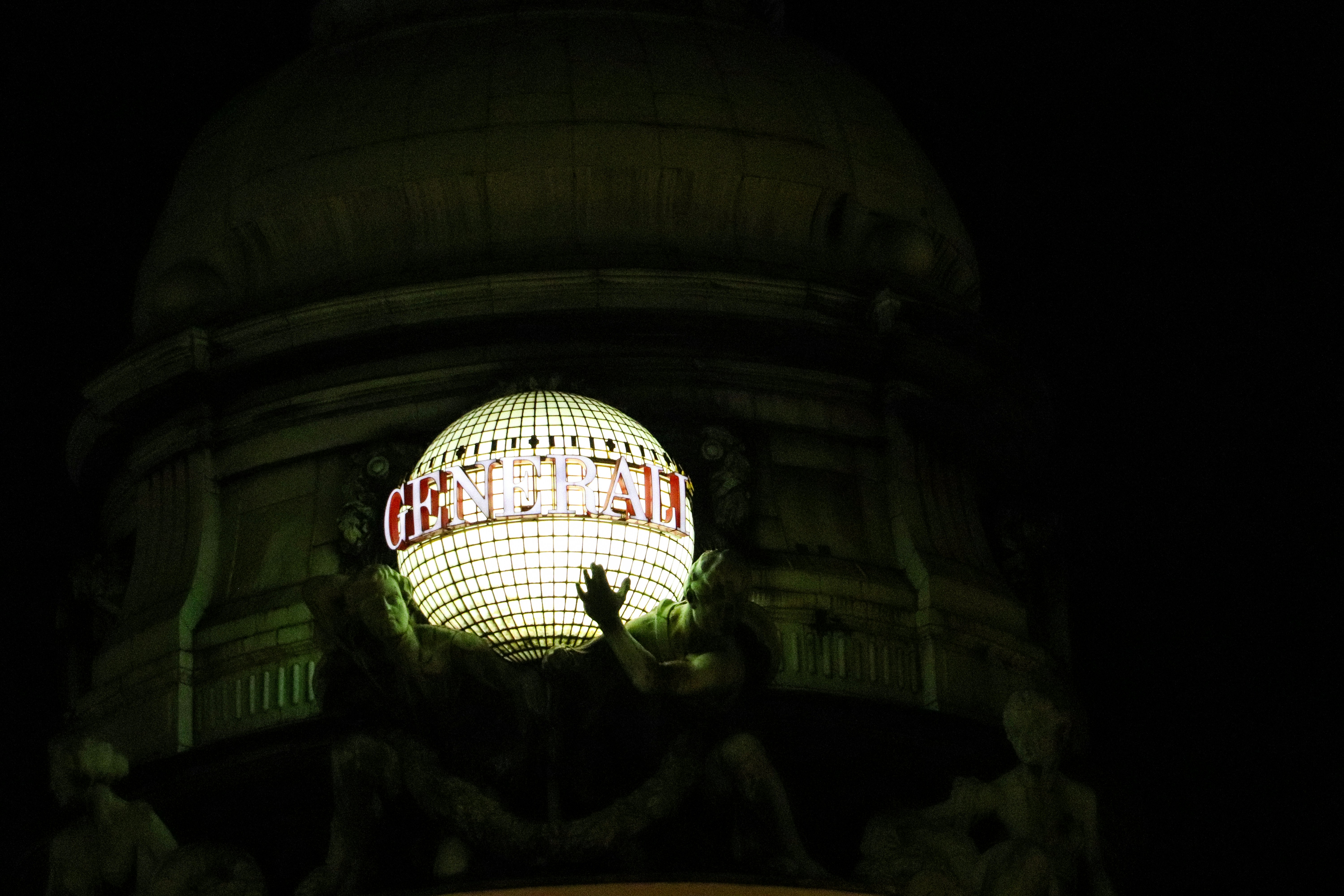 Neon Globe: The Central Sign Illuminating a Sculpted Night Facade