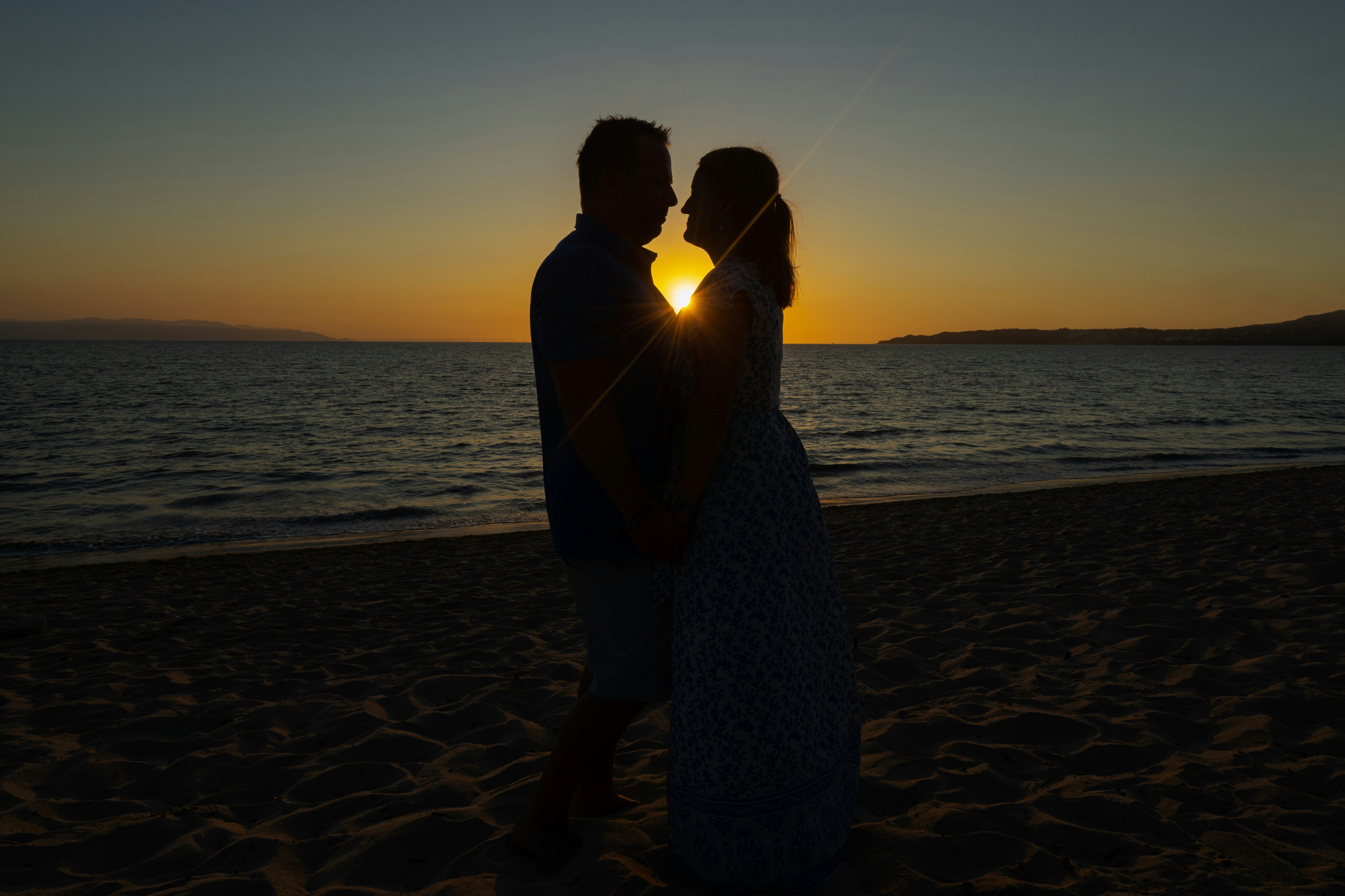 A man and a woman standing on a beach at sunset photo – Free Bucerías ...