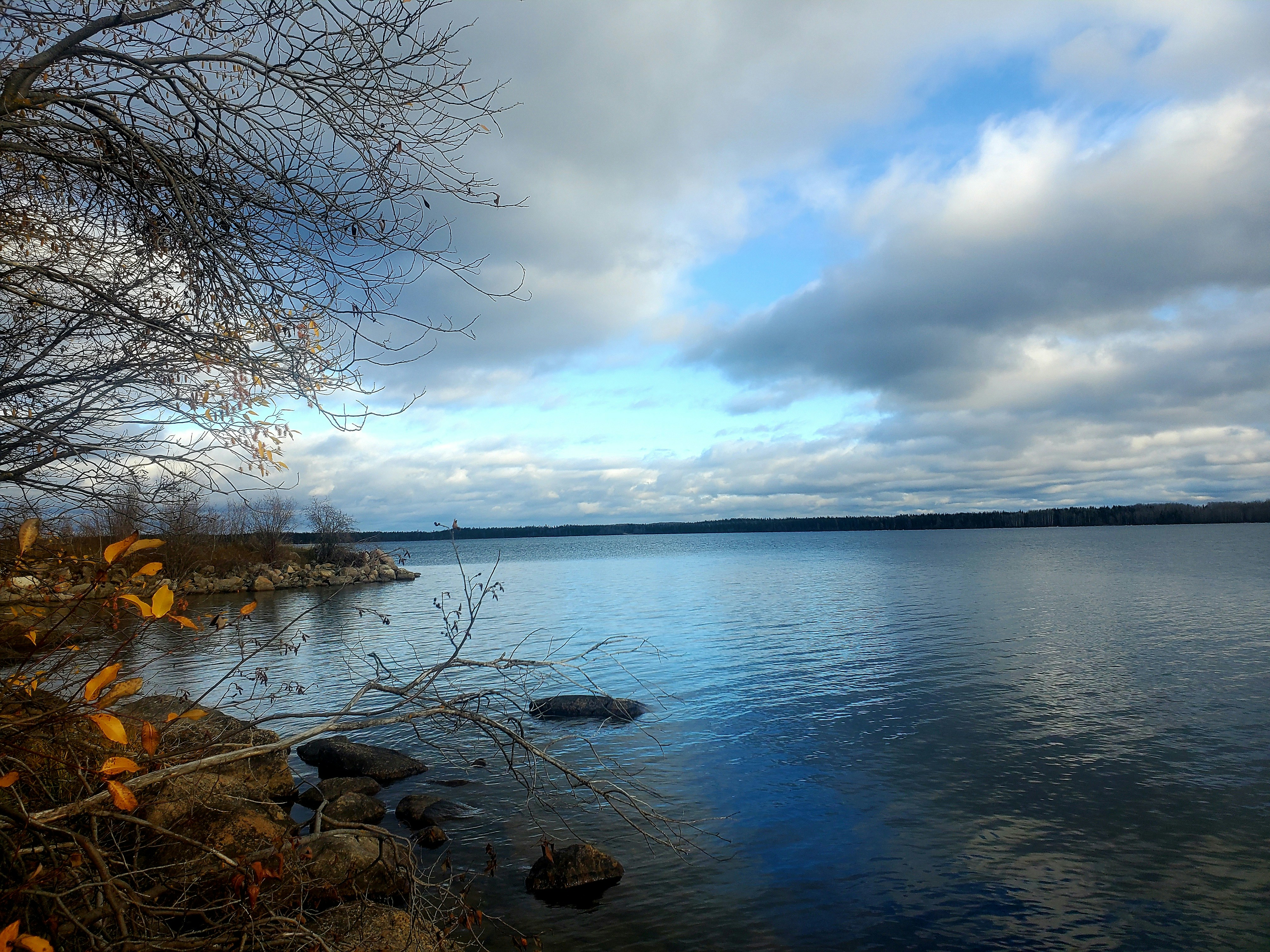A body of water surrounded by trees and rocks photo – Free Bearskin ...
