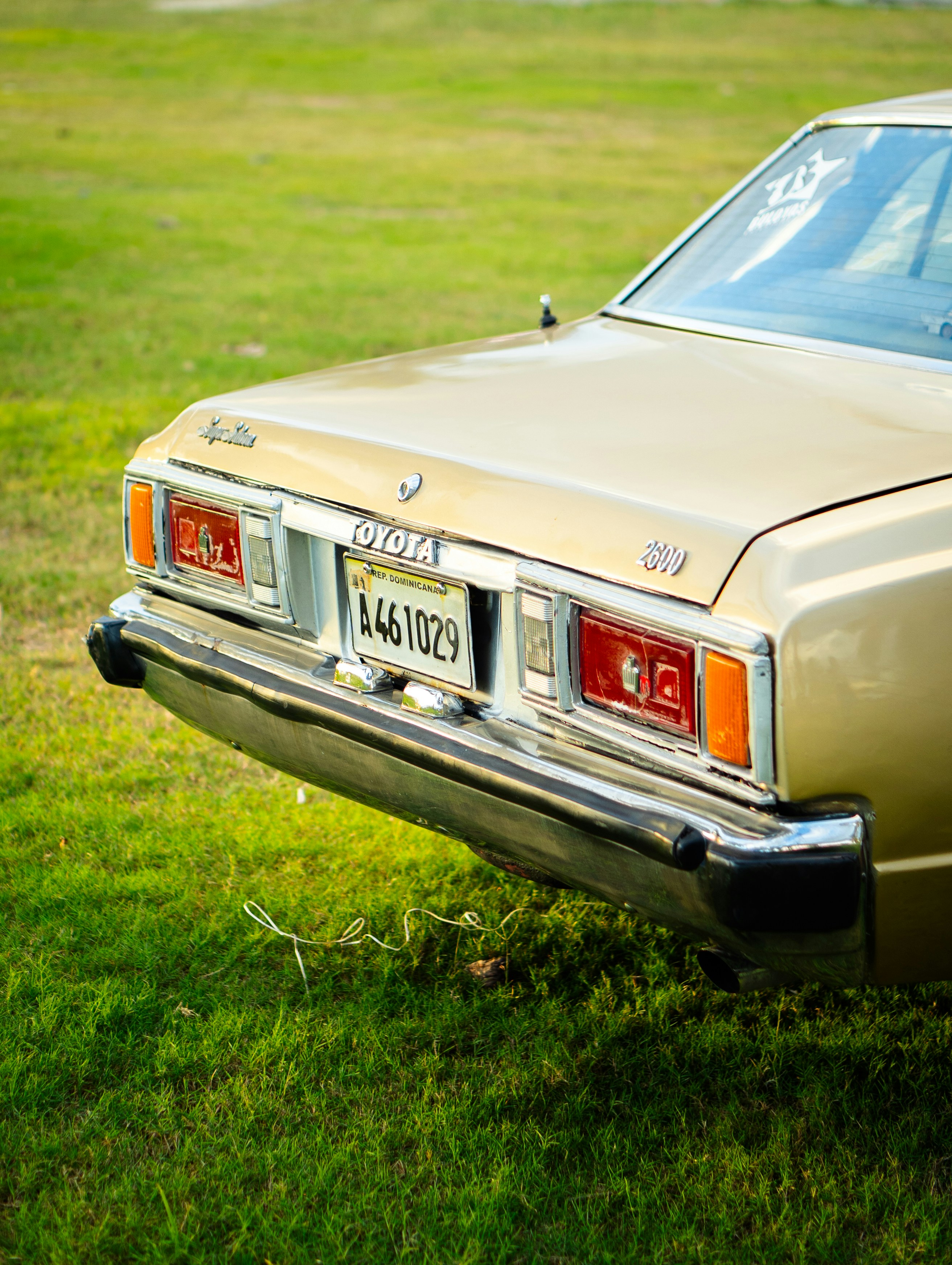 A tan car parked on top of a lush green field photo – Free Santo ...