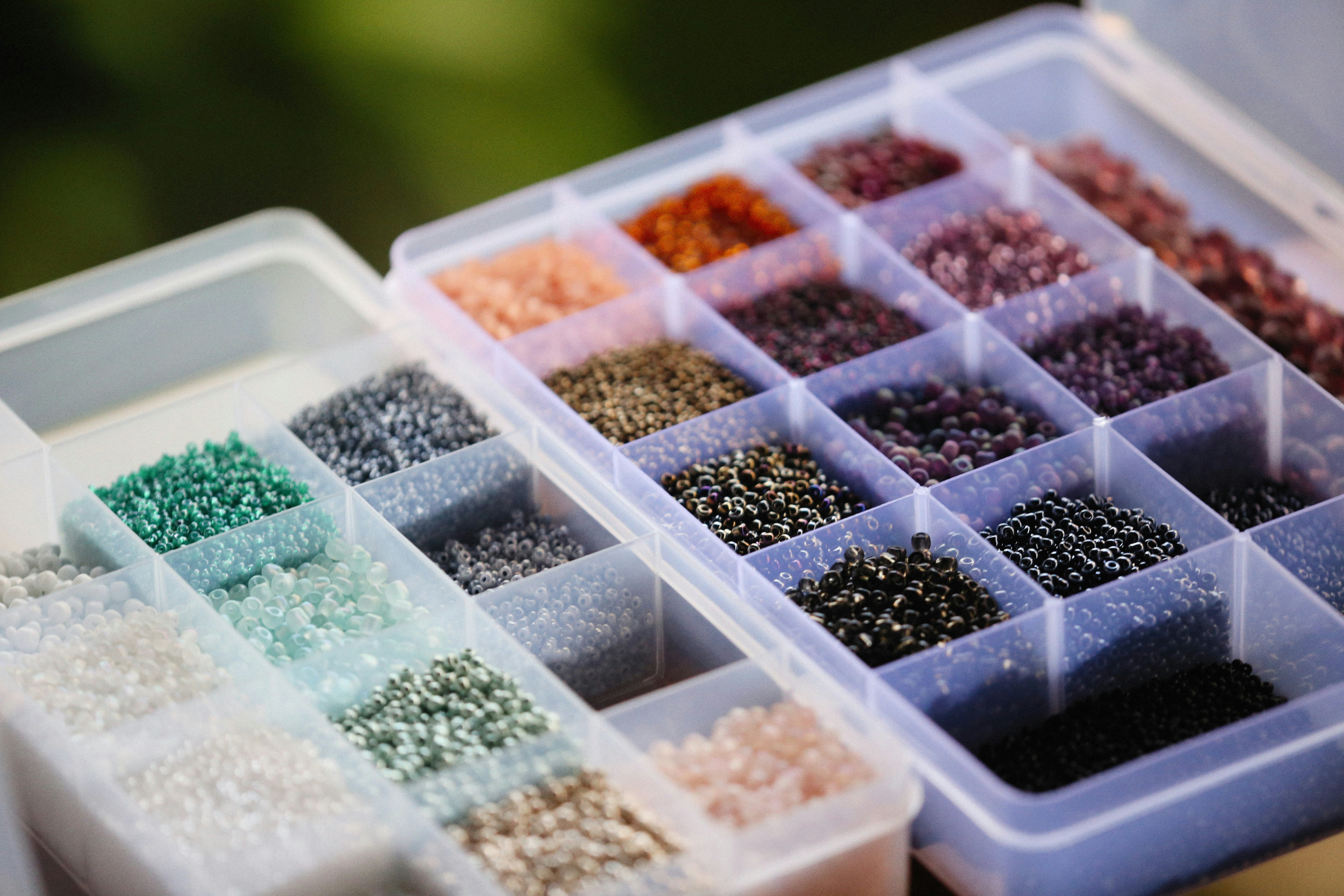 A plastic container filled with lots of different colored beads photo ...