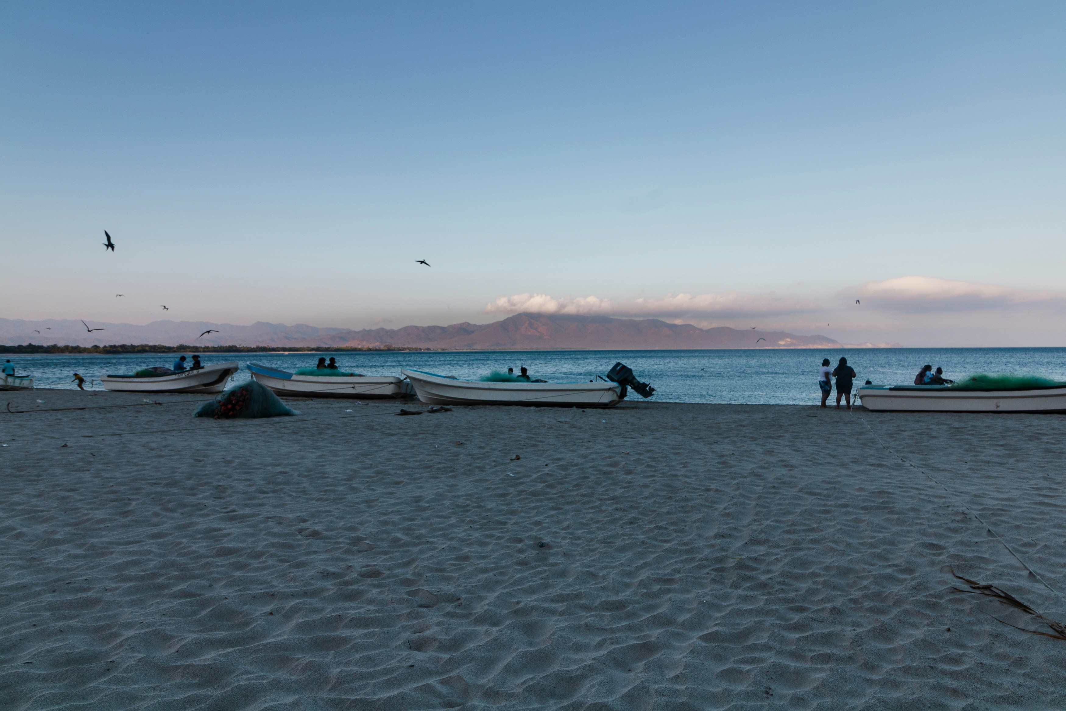 Boats Rest Along a Quiet Shoreline Under a Clear Coastal Sky