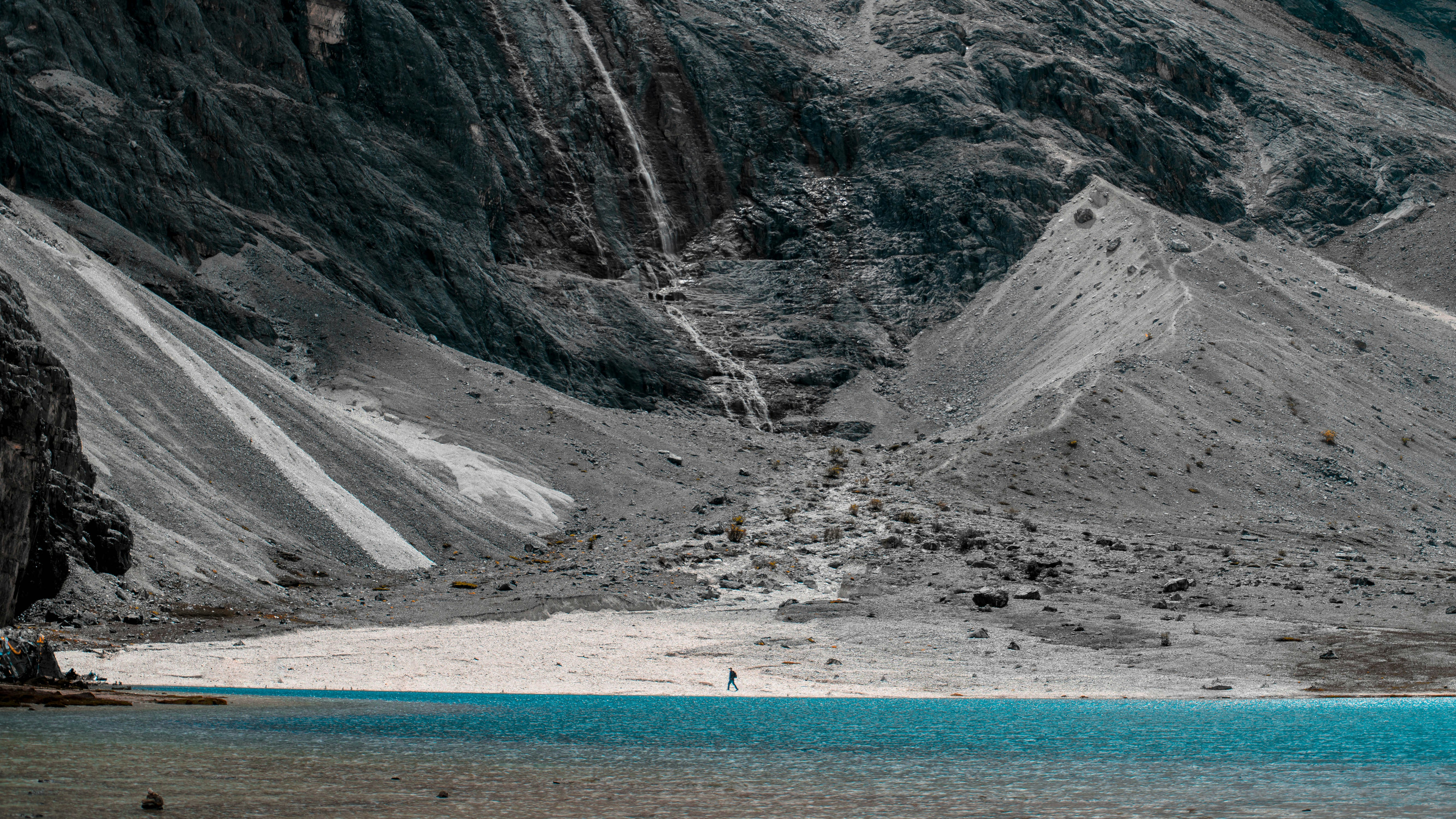 Azure Ledge: A Lone Figure at the Glacier-Edge Shore