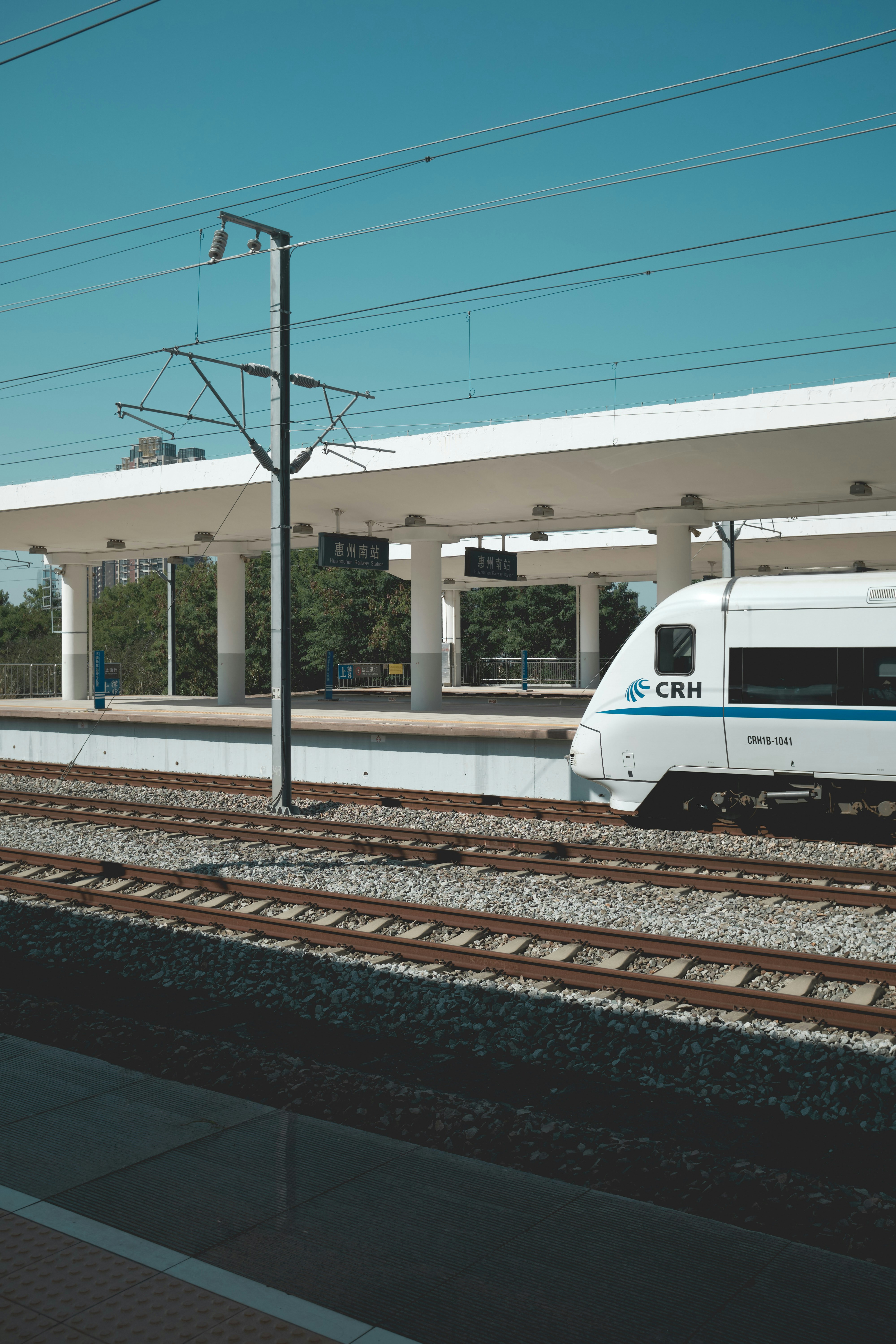 a white train traveling past a train station