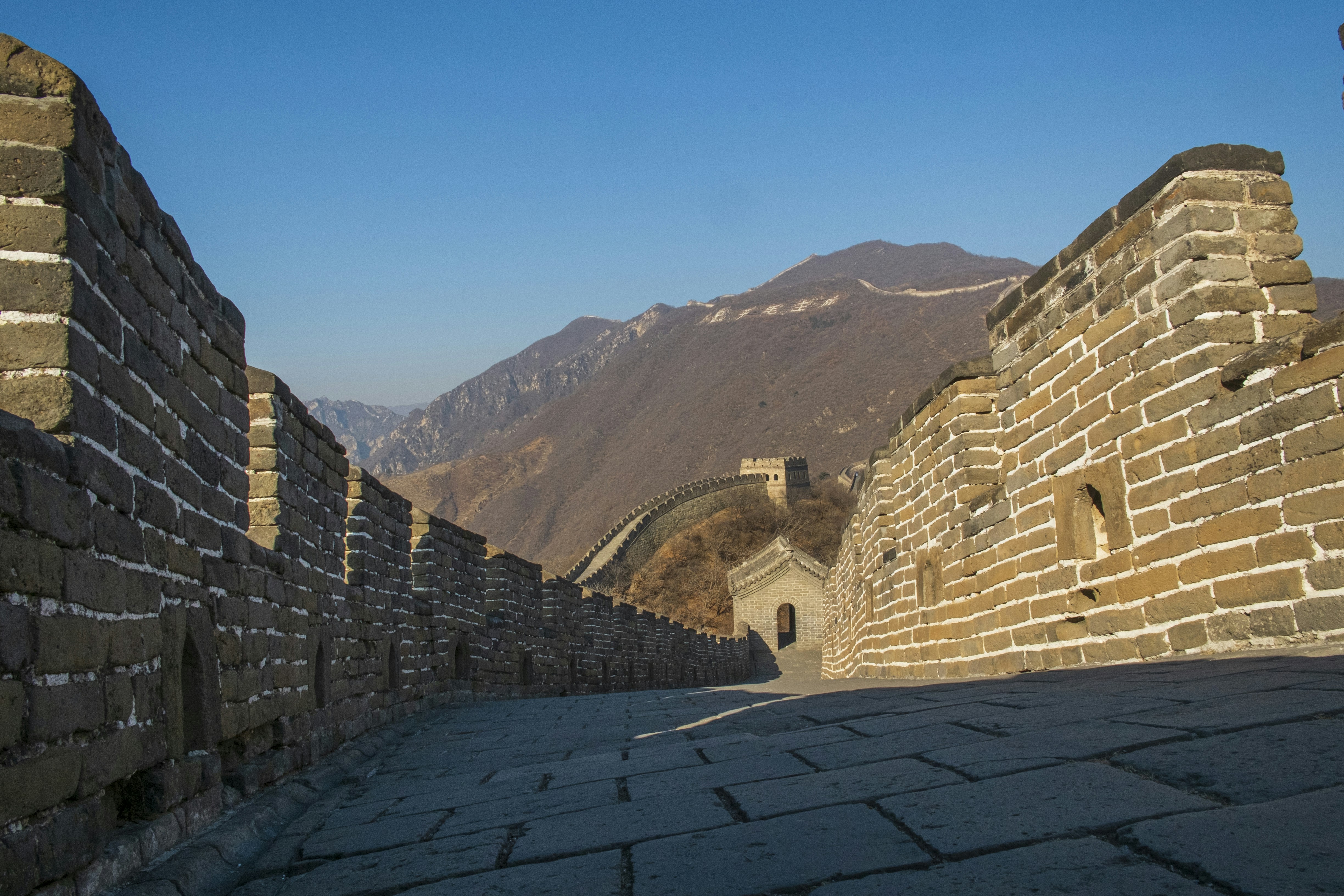 a view of the great wall of china with mountains in the background