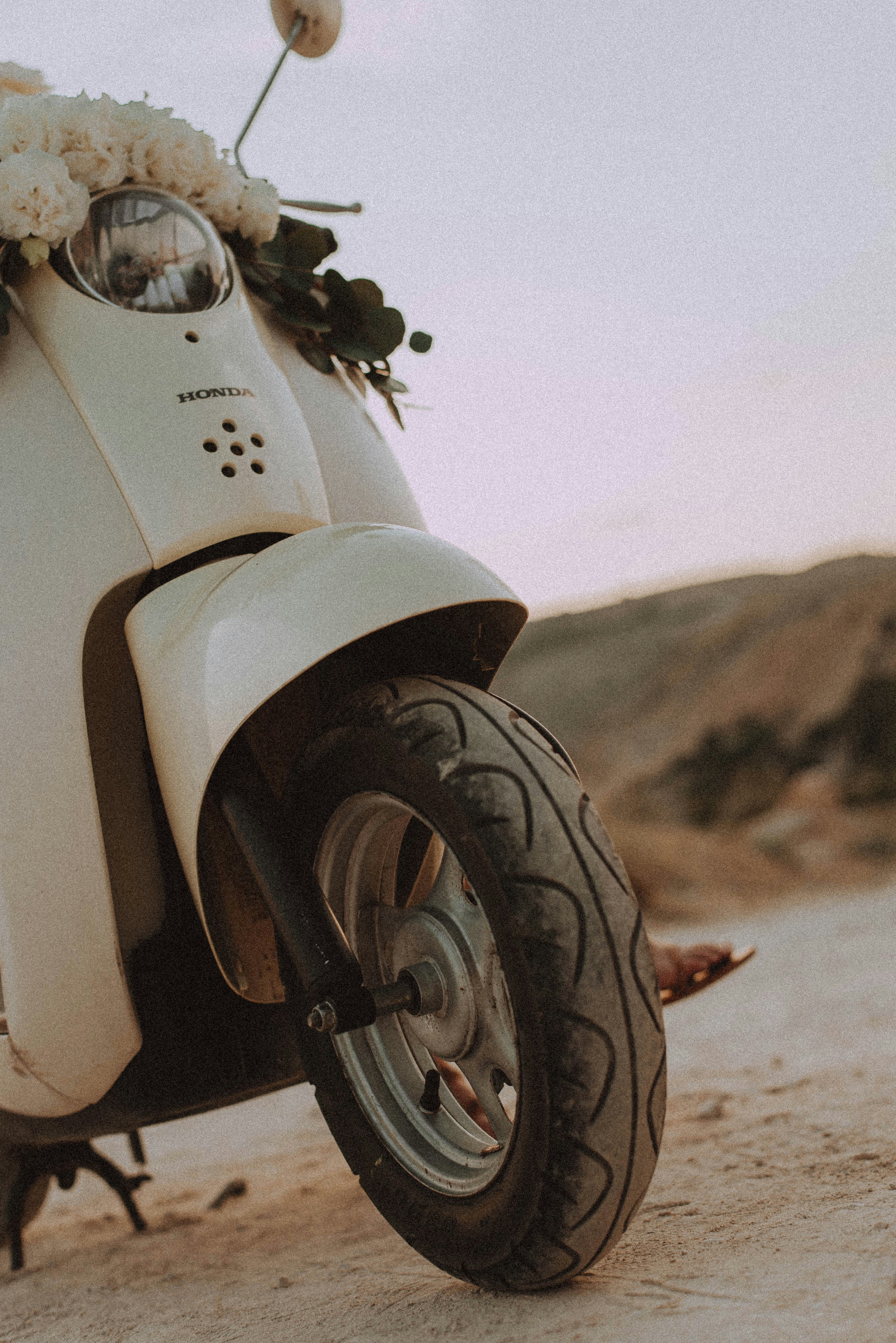 Vintage Love: A Cream Vespa Resting on Sandy Horizon