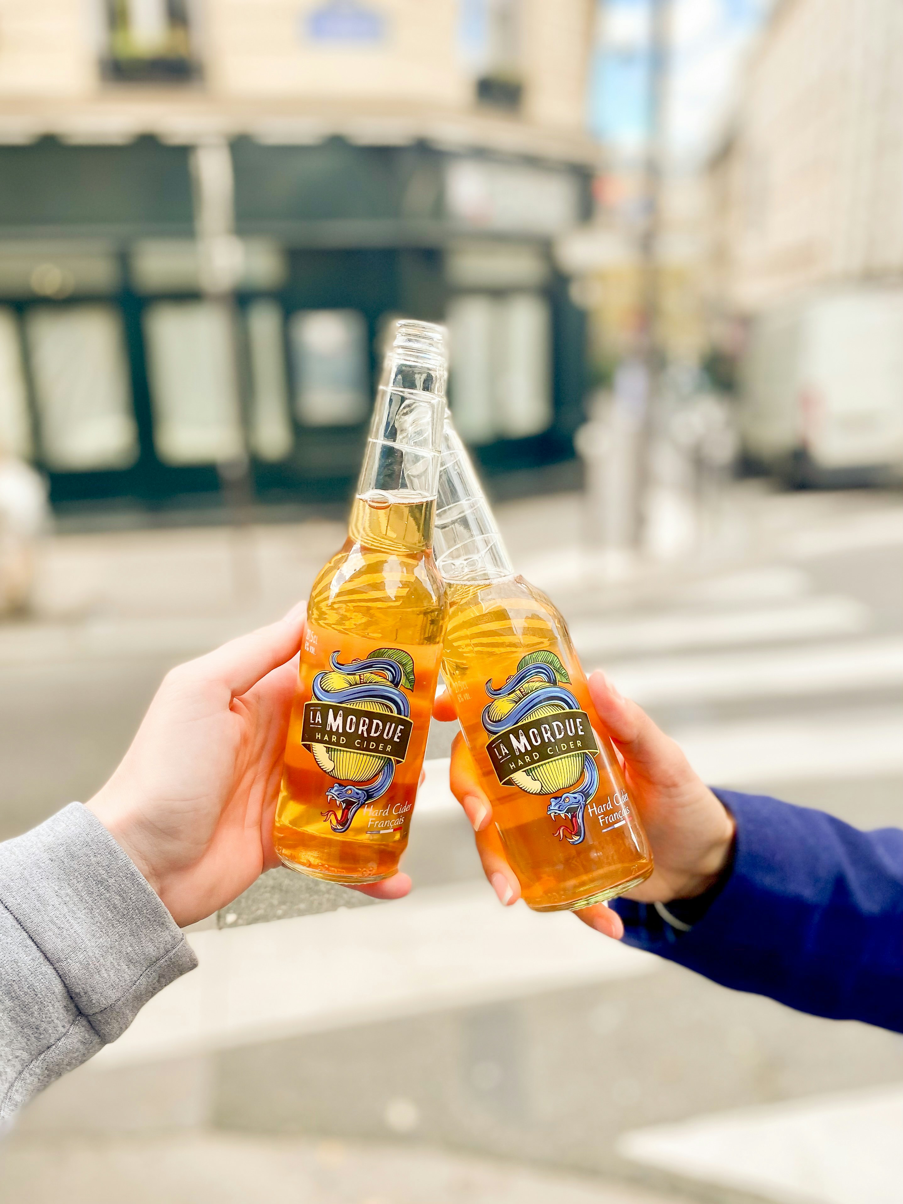 Urban Toast: Twin La Mordue Bottles Clink in a City Blur