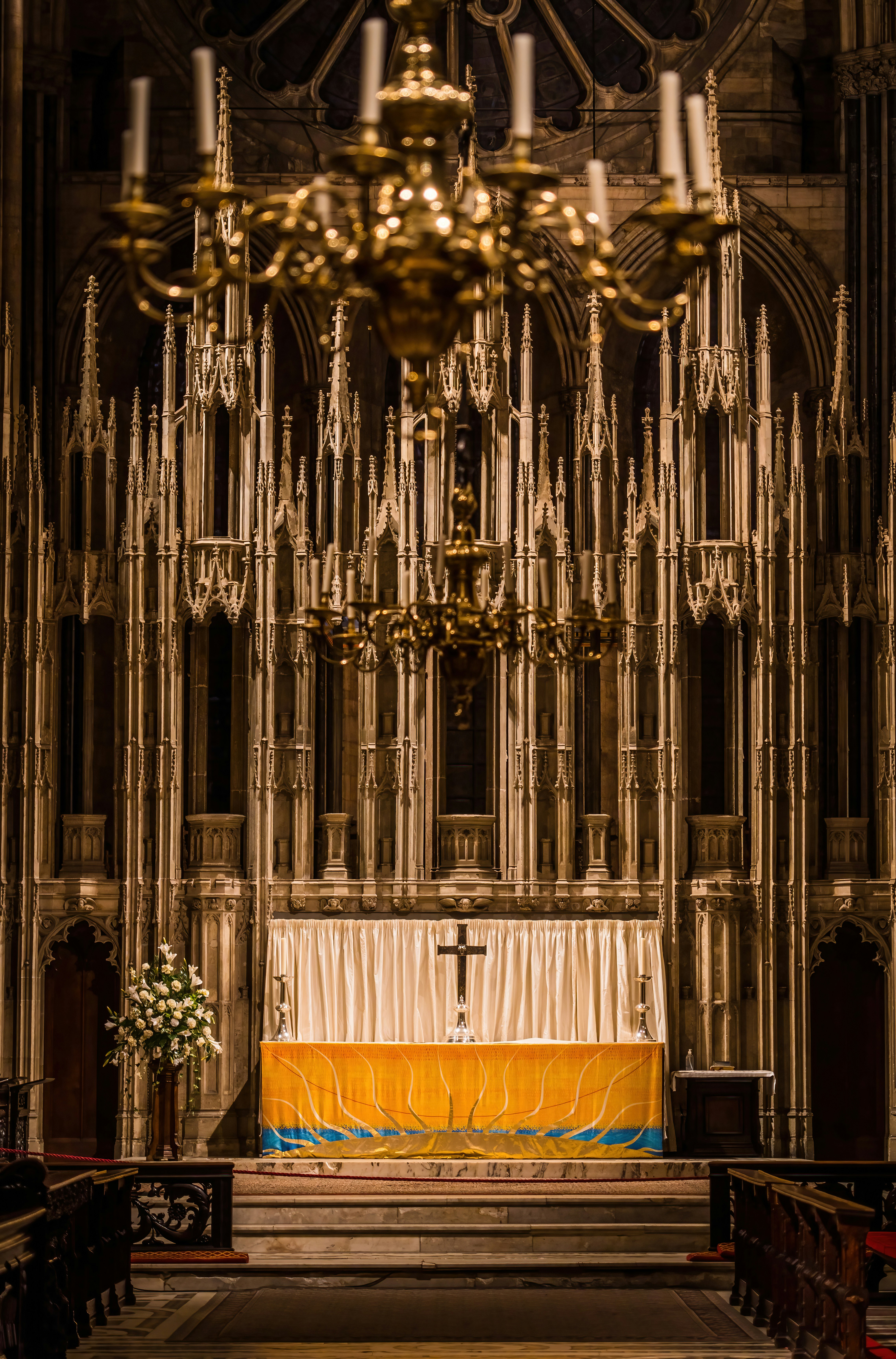 a church with a chandelier and a cross on the alter